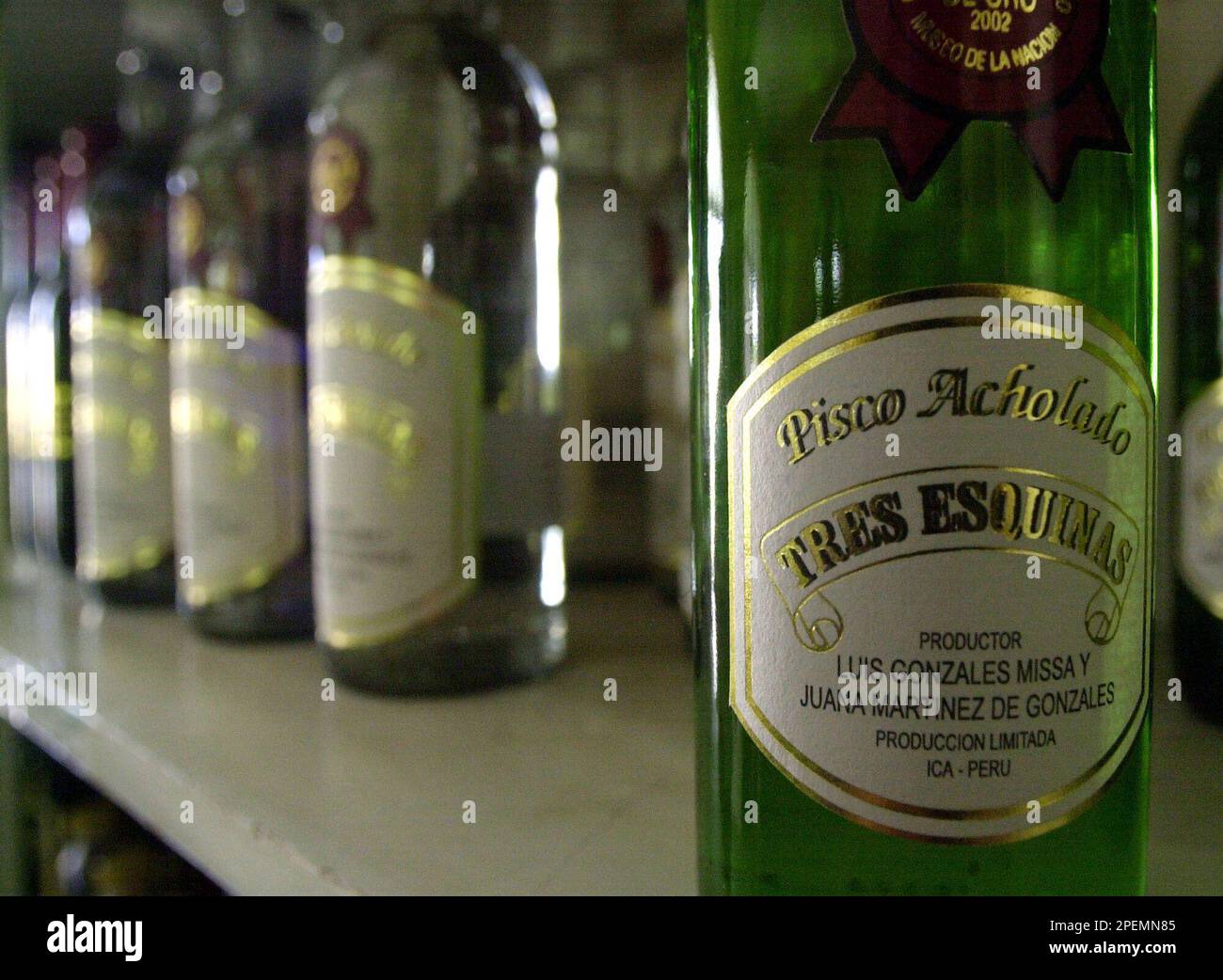 Bottles of pisco line a shelf at the Tres Esquinas vineyard in Ica, 165 ...