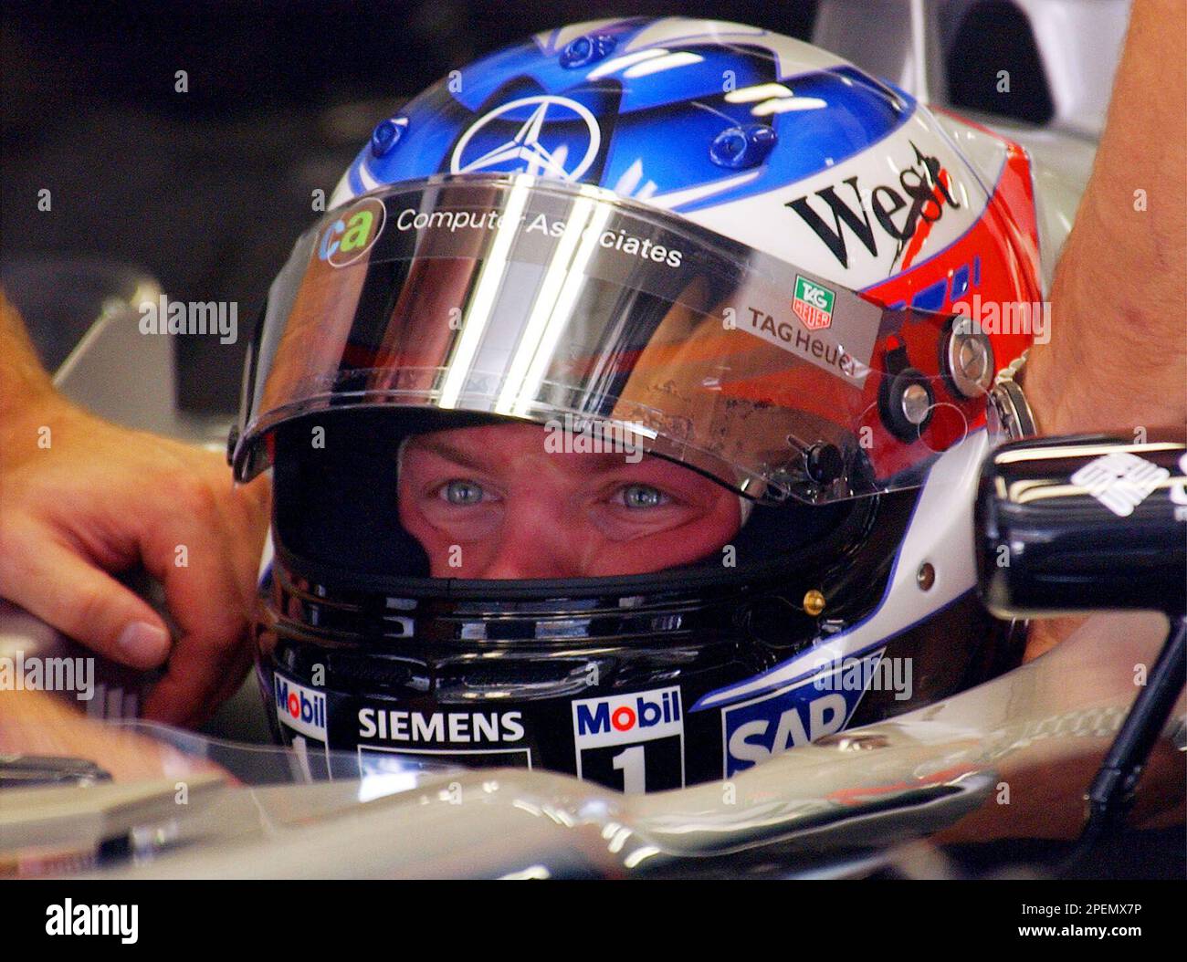 McLaren's Kimi Raikkonensits in the cockpit of his car as he gets ready ...