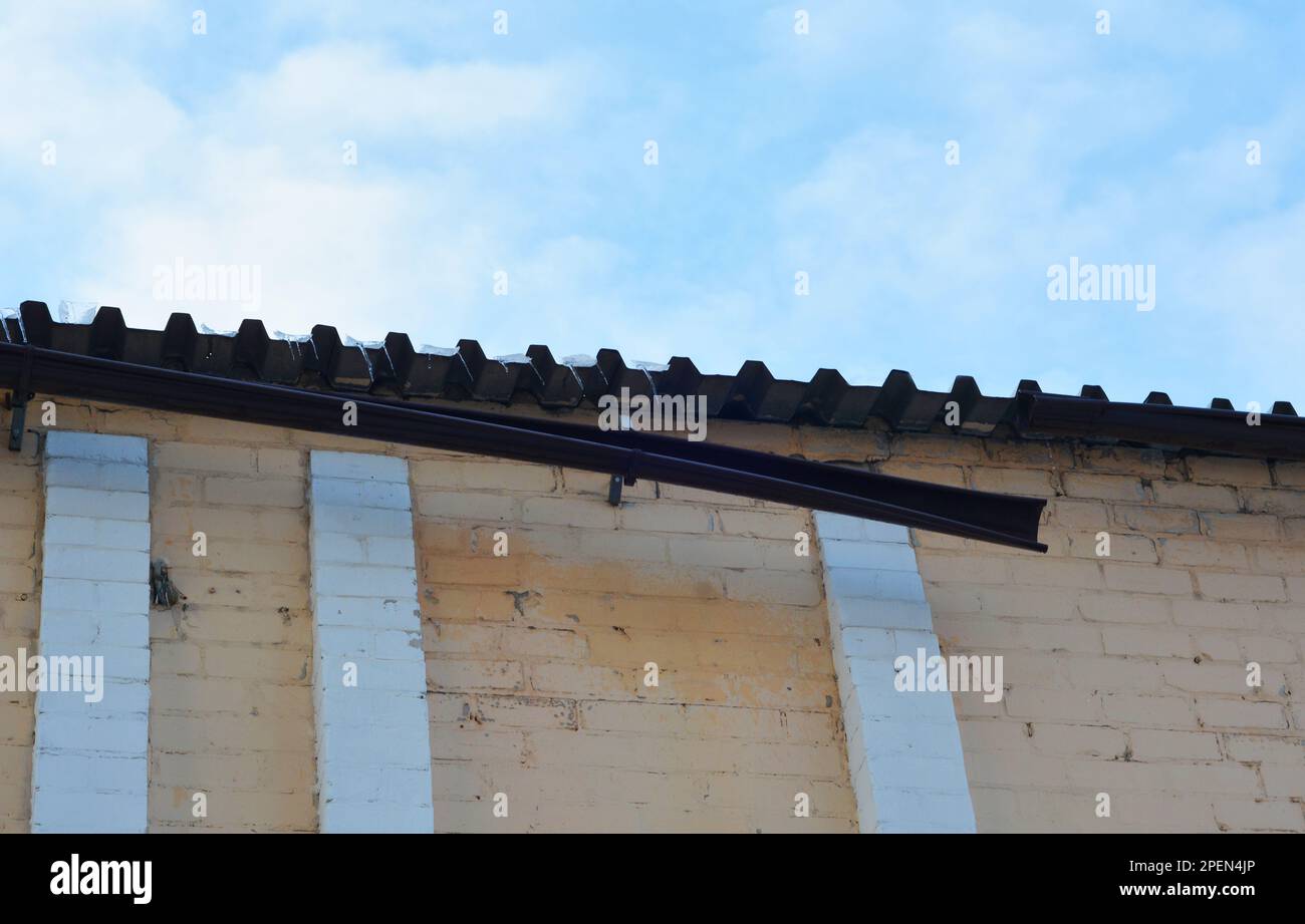 Broken Rain Gutters. Close up on roof gutter ice dam. Icicles damage ...