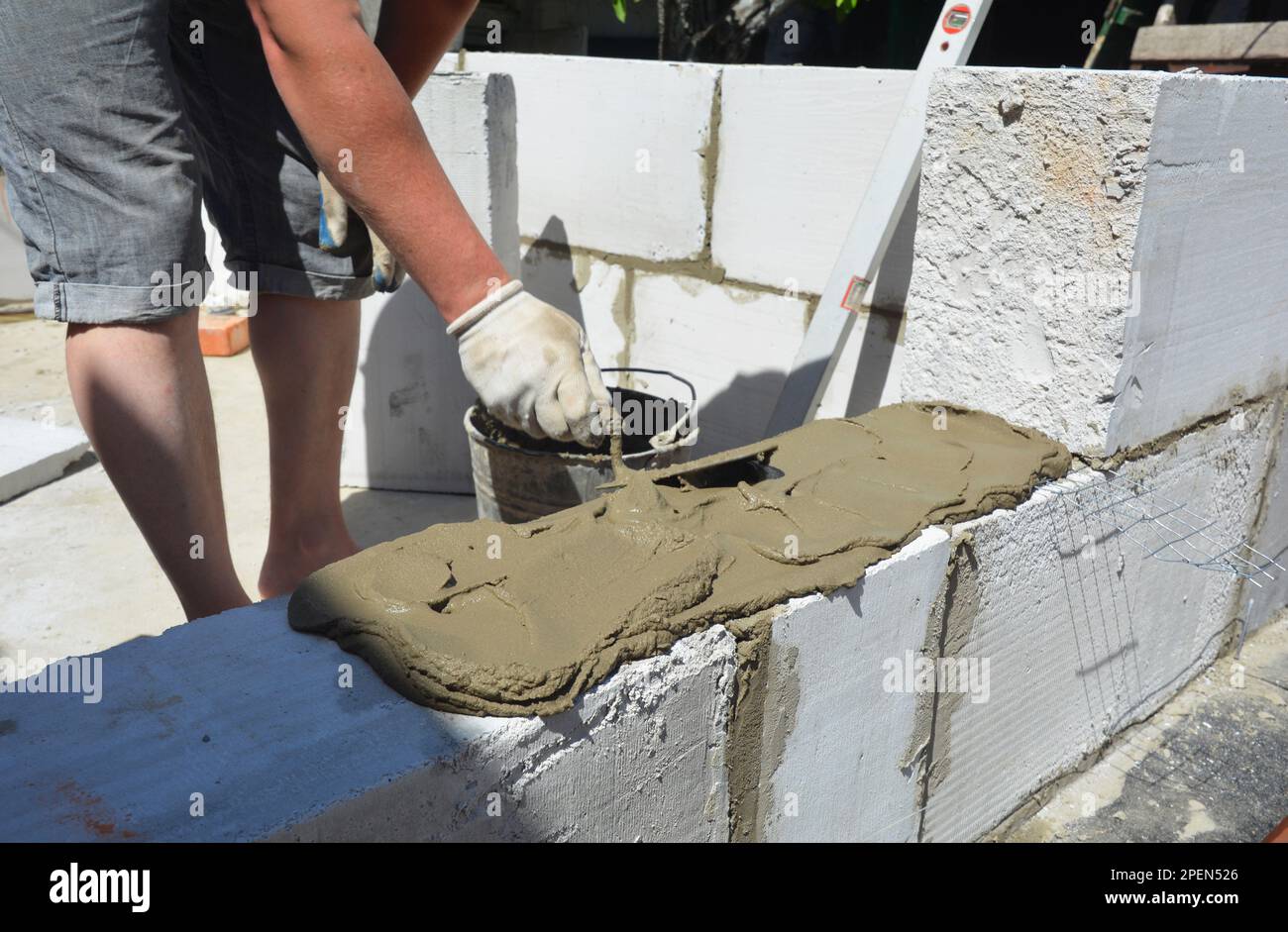 Builder contractor laying white autoclaved aerated concrete AAC blocks ...