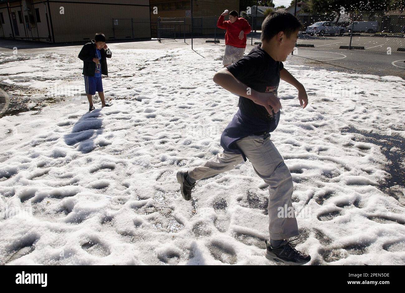 Andy Zhu, 11, right, dodges hail thrown by his friends Austin Owensby ...