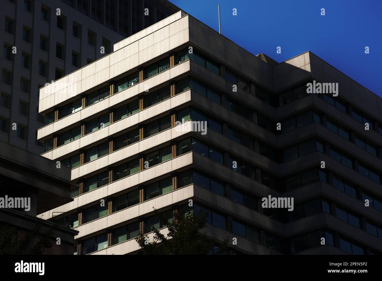 Two modern buildings side by side in a vibrant cityscape, set against a ...