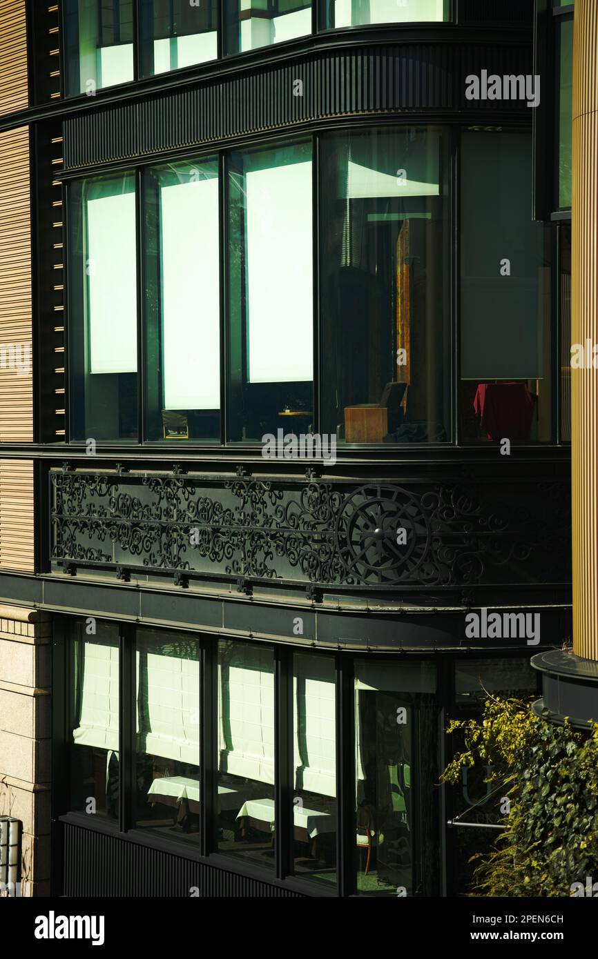 A modern building exterior is featured, with a balcony and multiple ...