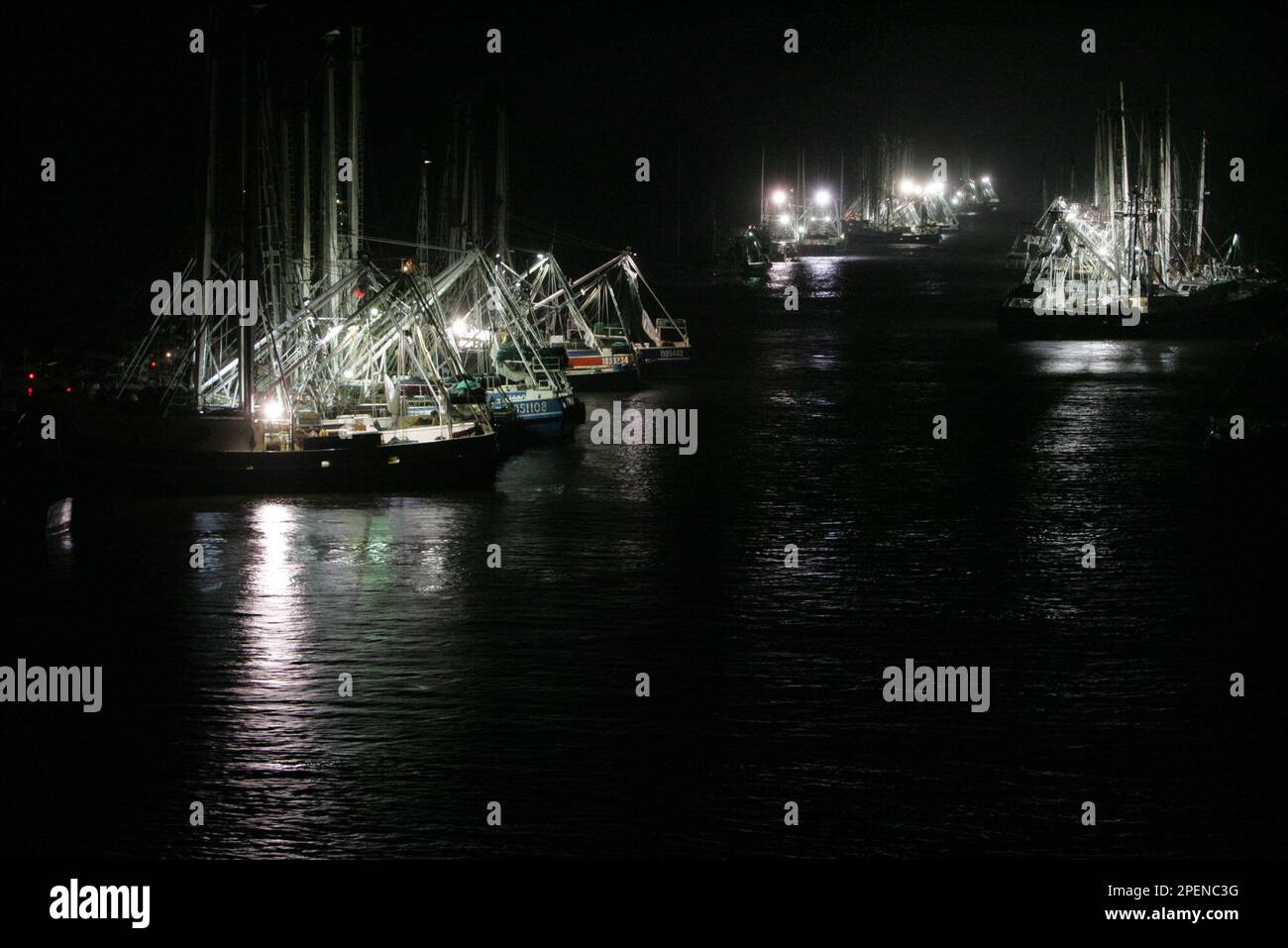 Shrimp boats, tied down on calm waters of an intercoastal waterway, are ...
