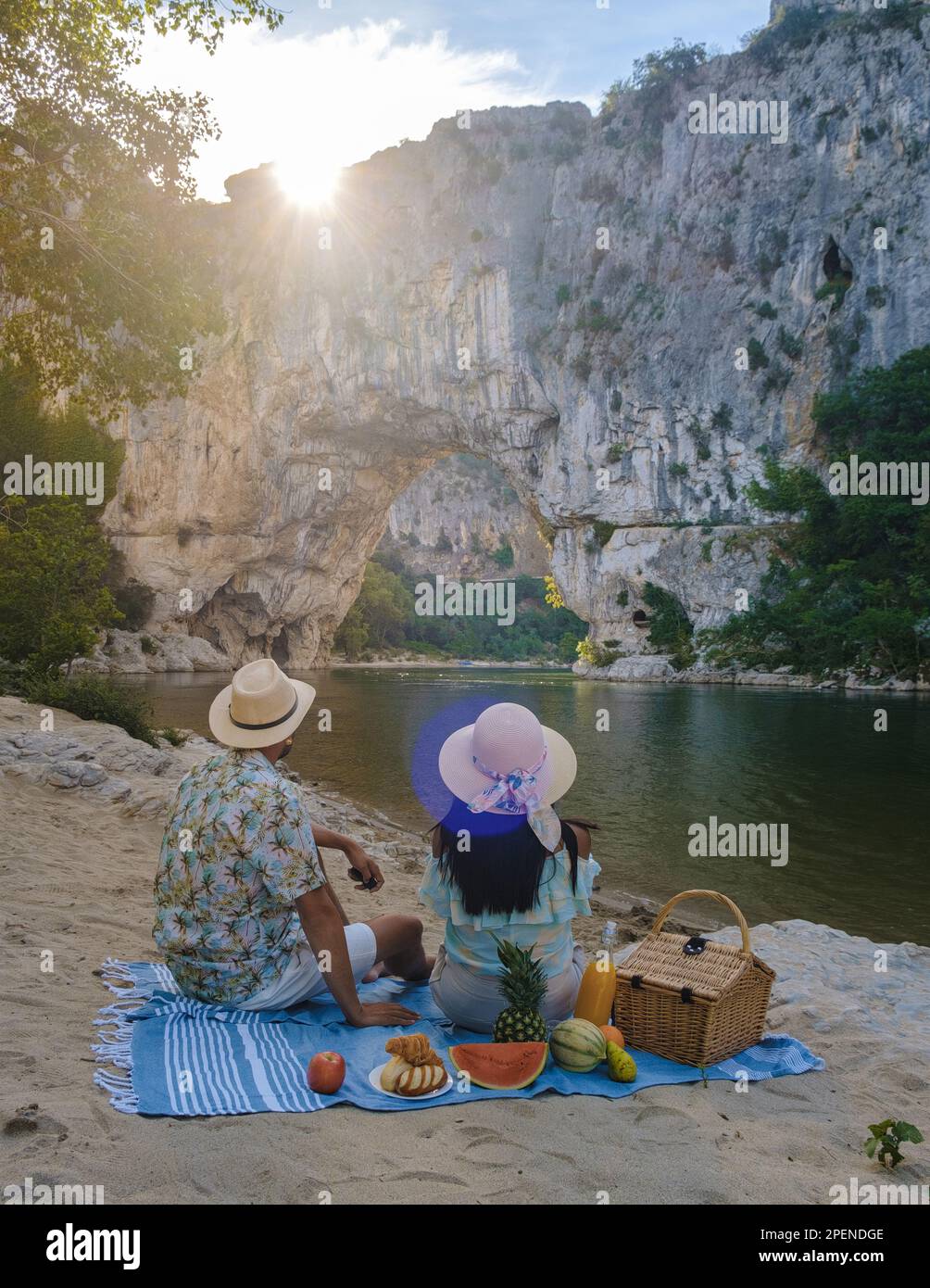 couple having picnic on the beach on vacation in the Ardeche France ...