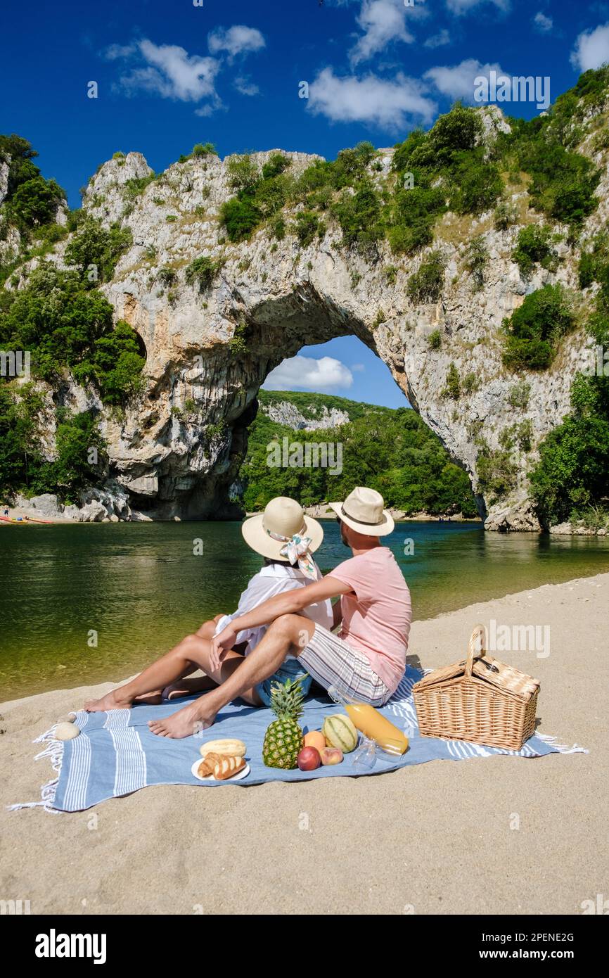 couple having picnic on the beach on vacation in the Ardeche France ...