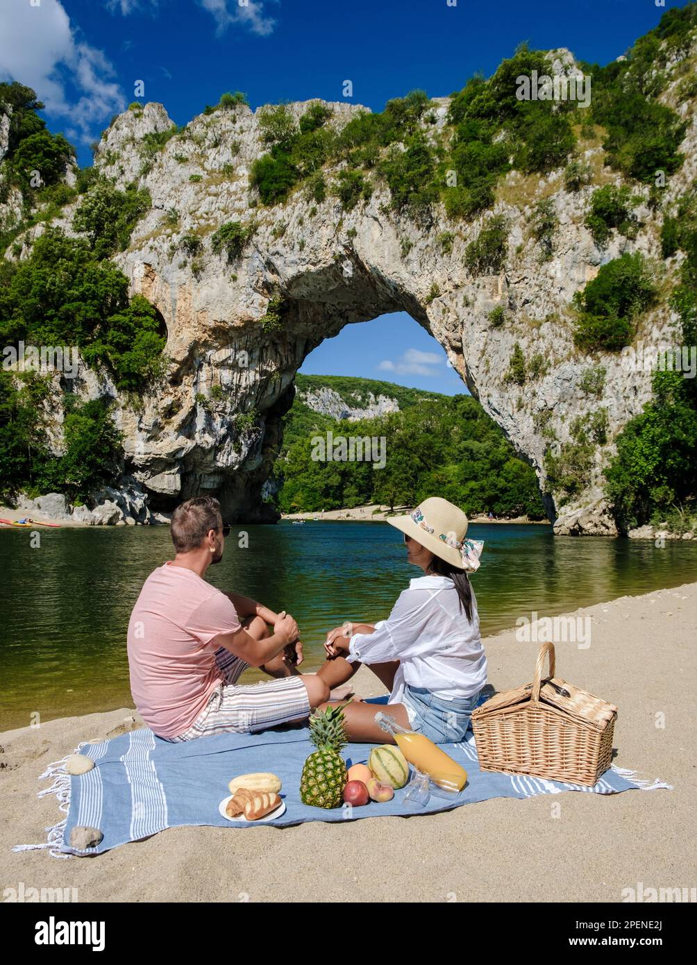couple having picnic on the beach on vacation in the Ardeche France ...