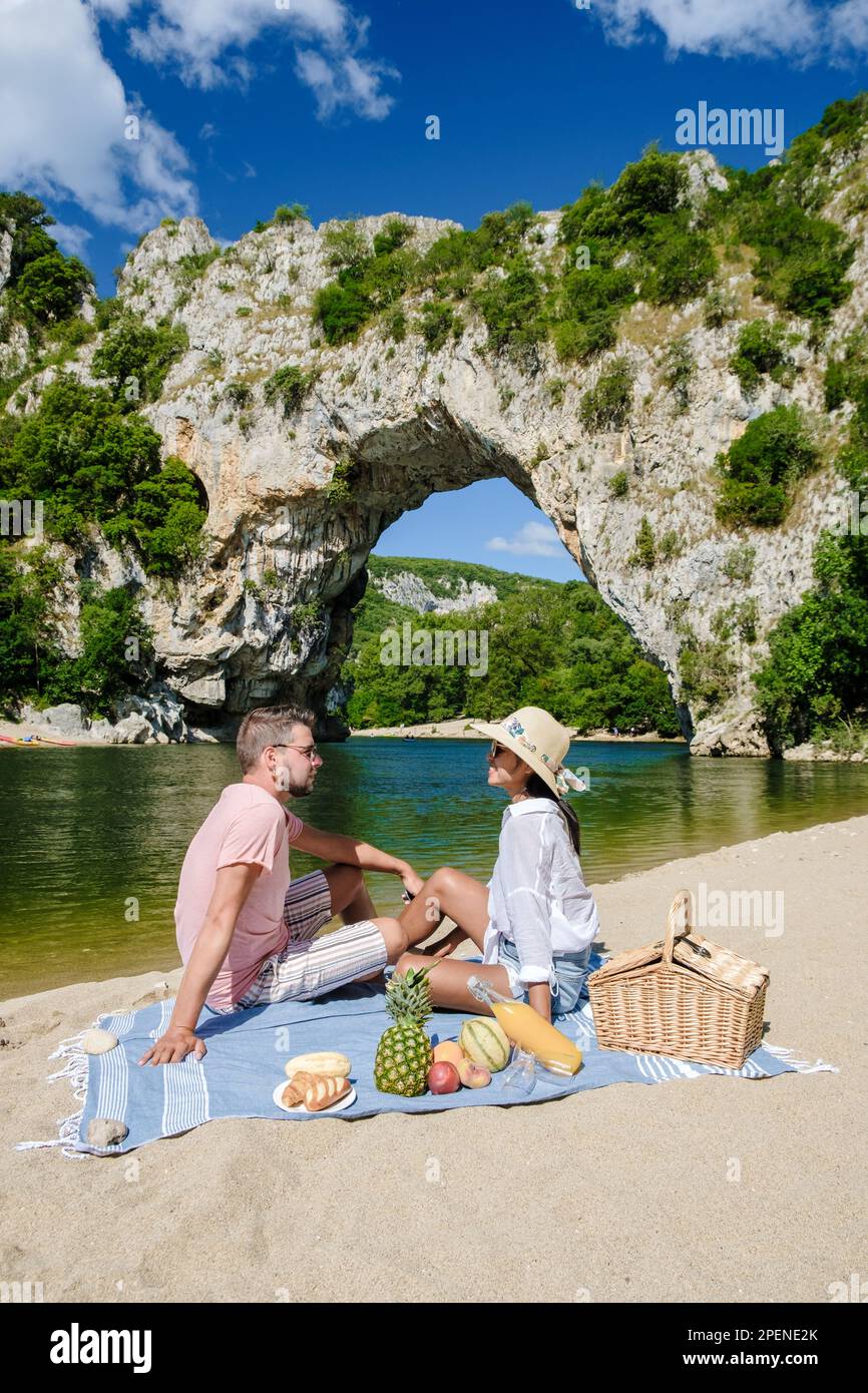 couple having picnic on the beach on vacation in the Ardeche France ...