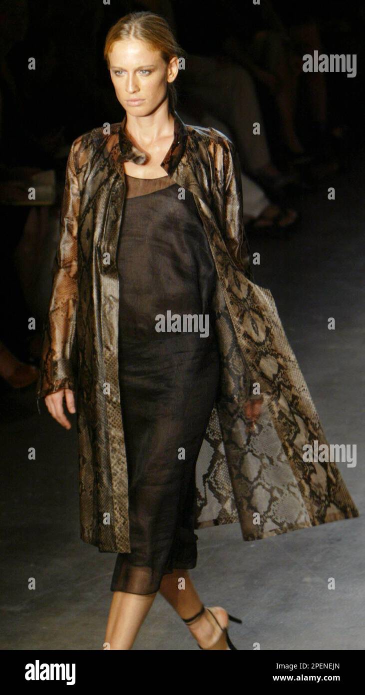 A model wears a transparent python trench coat with a black silk and ...