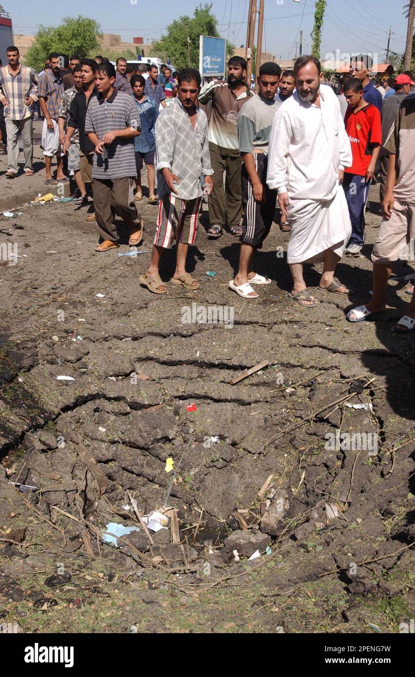 Iraqis look to the site of a massive explosion outside a police station ...