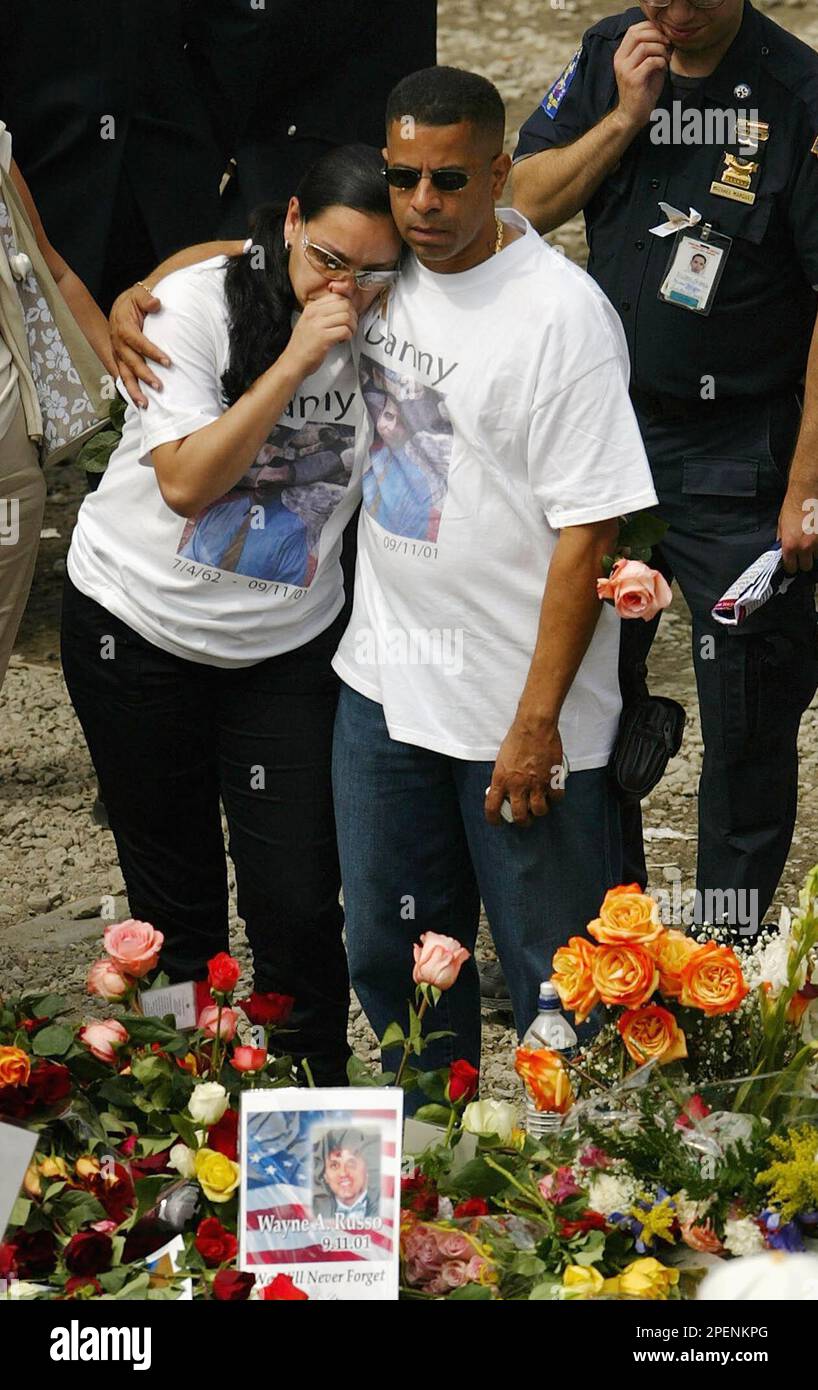 Two people stand at a memorial during the ceremony honoring the World ...