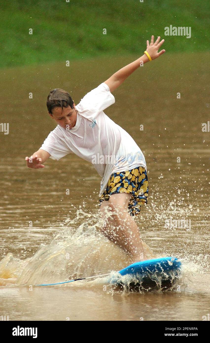 Daniel Wilson, 13, of Huntington, W.Va., surfs in floodwater at Ritter ...