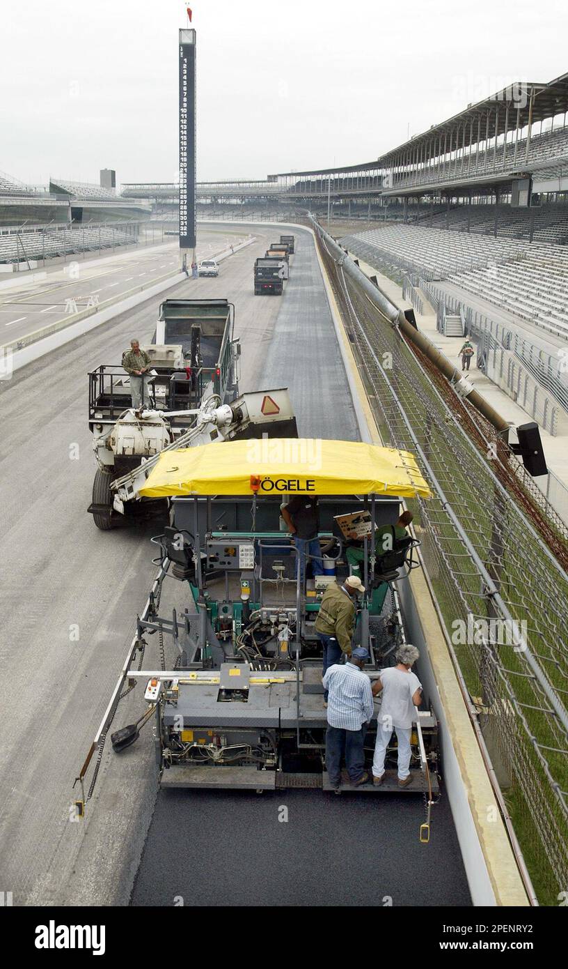 Workers at the Indianapolis Motor Speedway head down the main straight ...