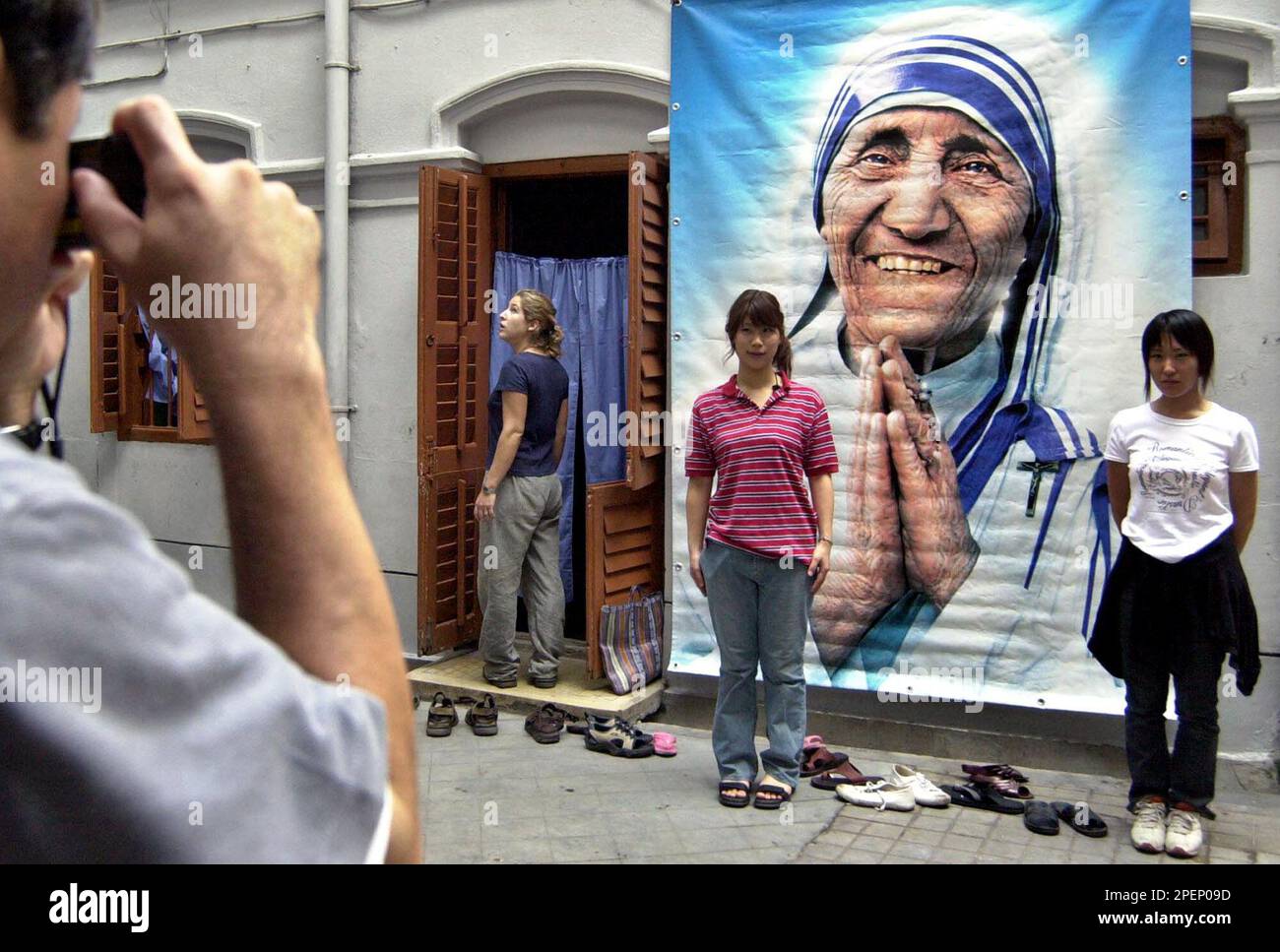Visitors get their photos taken in front of a photograph of Mother ...