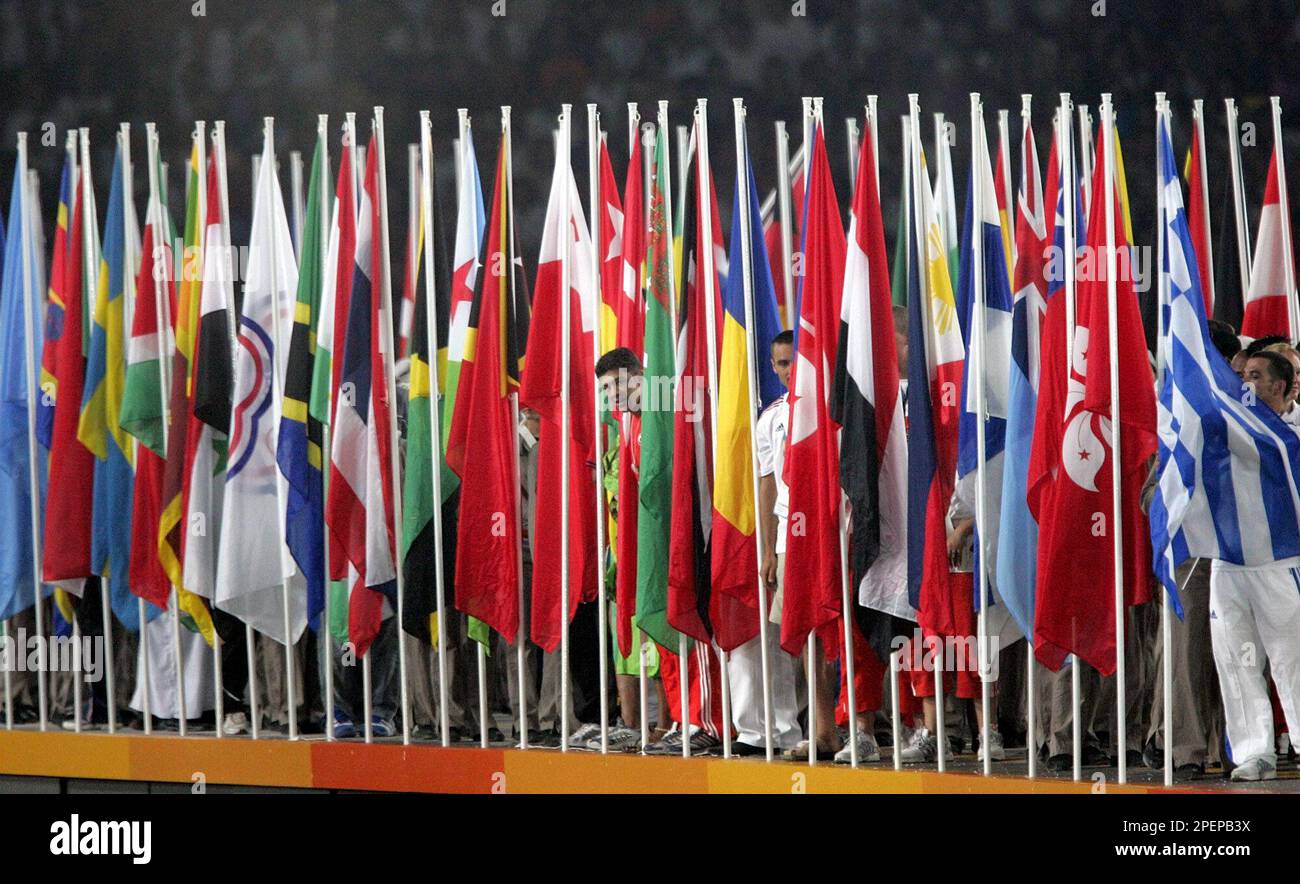 An athlete peeks between flags during the closing ceremony for the 2004 ...