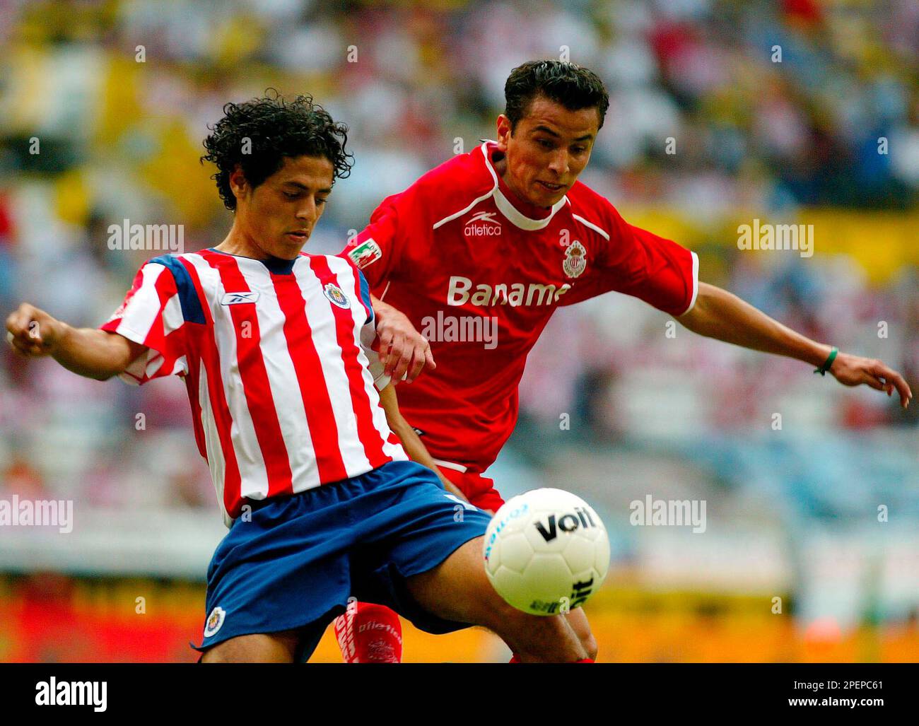 Chivas player Alejandro Vela, left, fight for the ball against Tolucas Mario Mendez during their ...