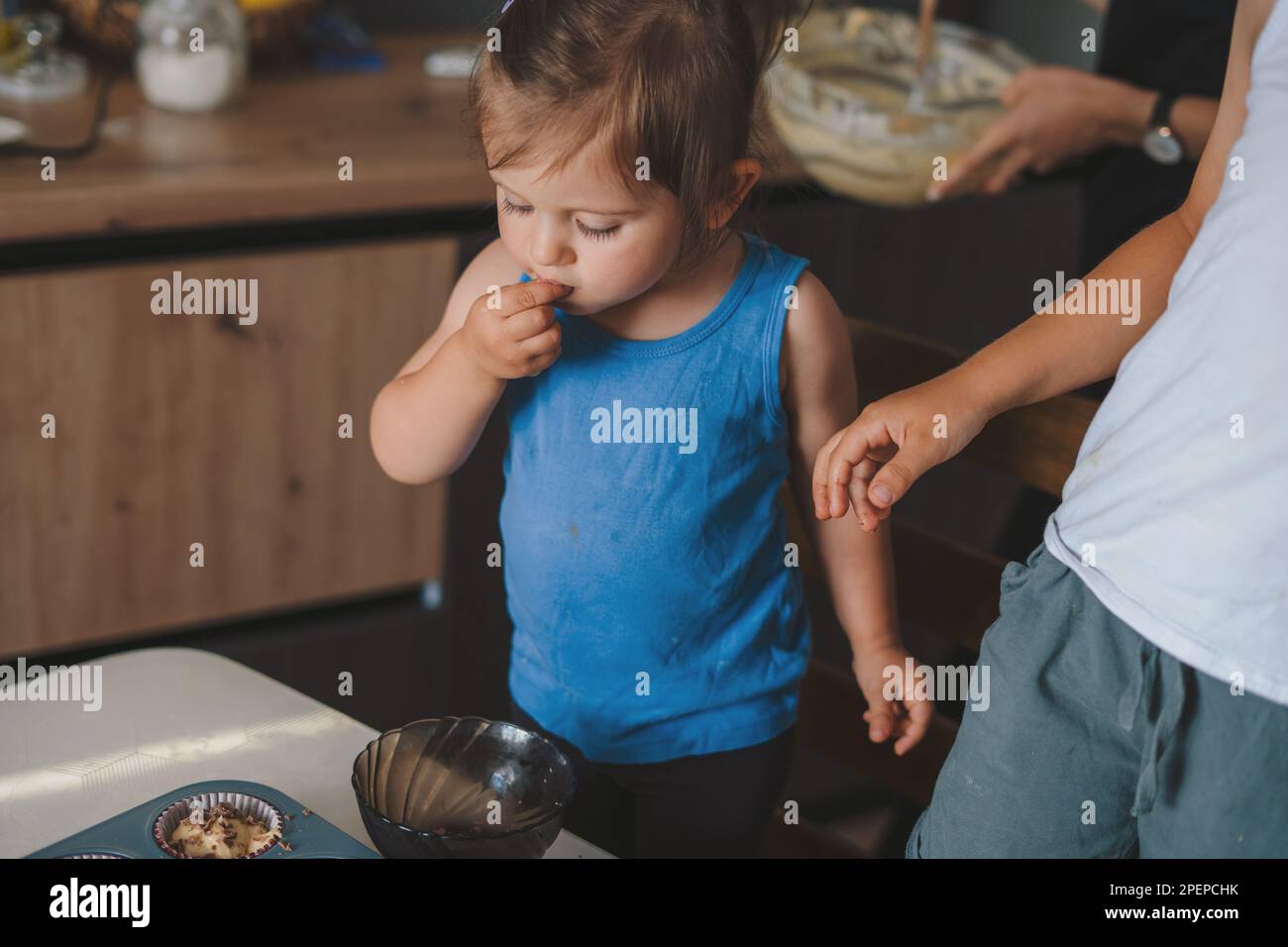 Cute little baby girl and her brother spooning muffin batter into the ...