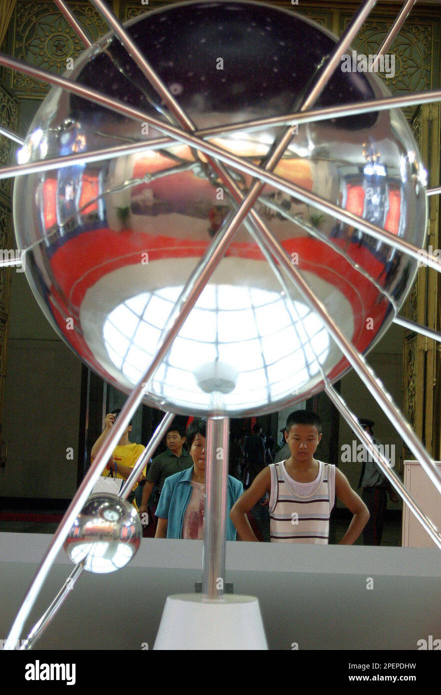 Chinese visitors stand near a sculpture representing nuclear power ...
