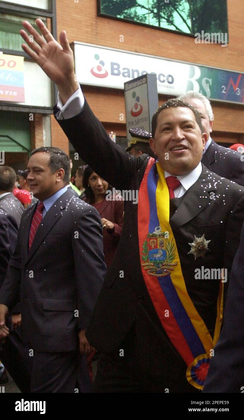 Venezuelan President Hugo Chavez waves to supporters as he walks from ...