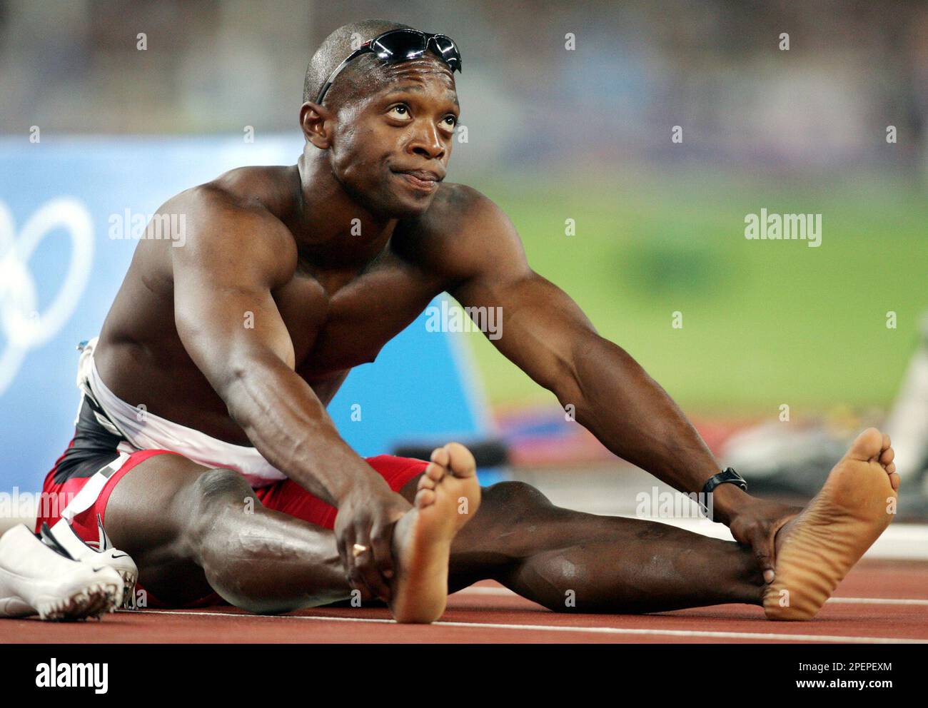 Canada's Charles Allen sits on the track after running in the 110-meter ...
