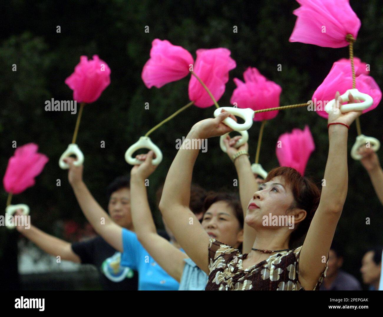 Chinese women perform a Chinese dance swinging weighted balls attached ...