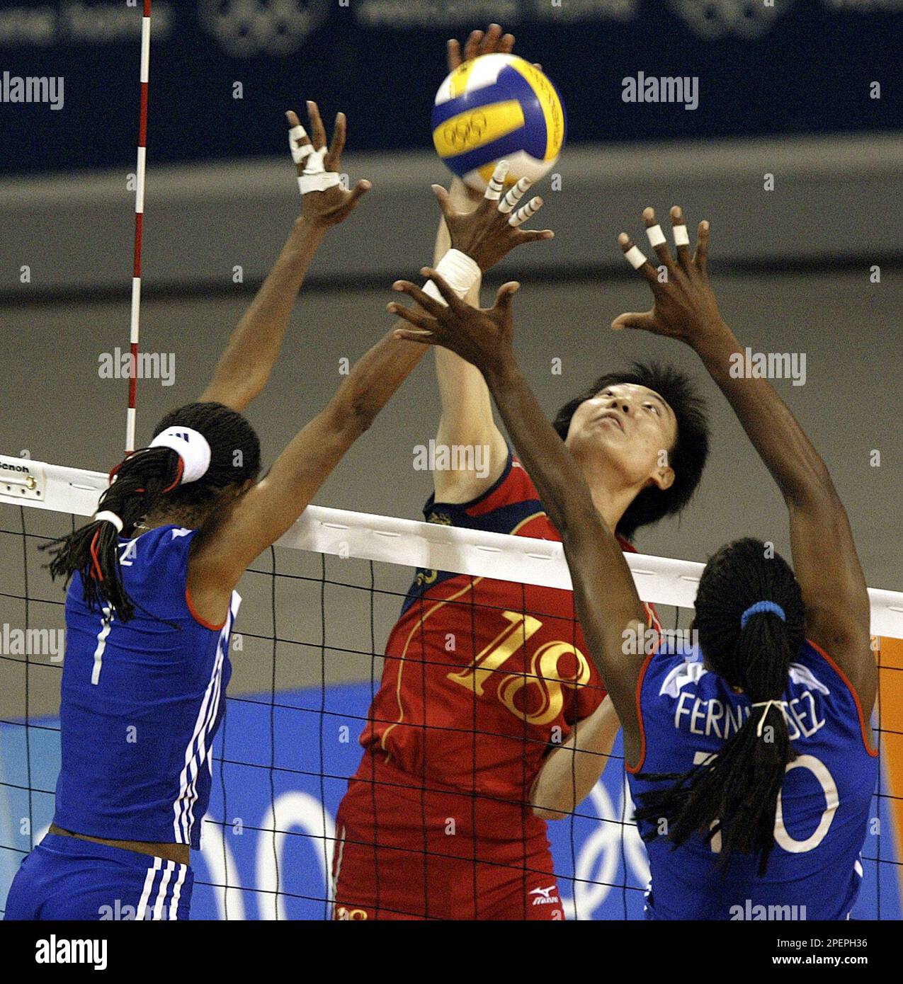 China's Zhang Ping (18) goes up for a spike with Cuba's Yumilka Ruiz ...