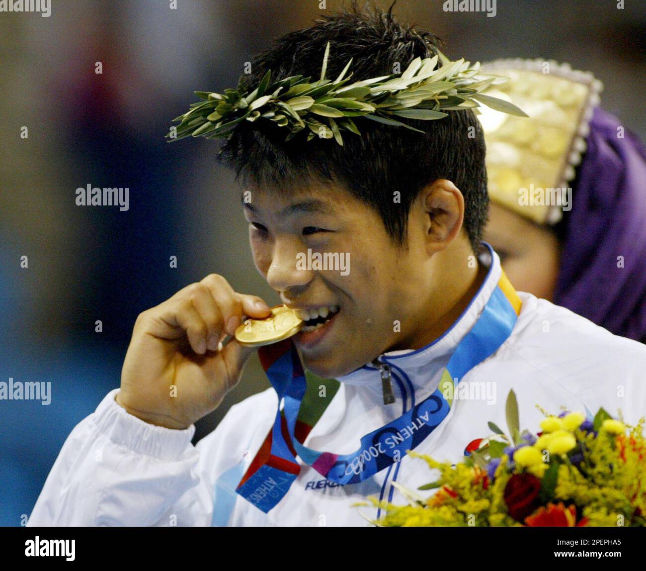 Jung Ji Hyum from Korea bites the gold medal he won during a Men's ...