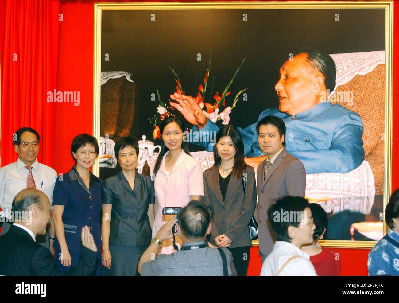 Visitors pose for pictures next to a portrait of China's late paramount ...