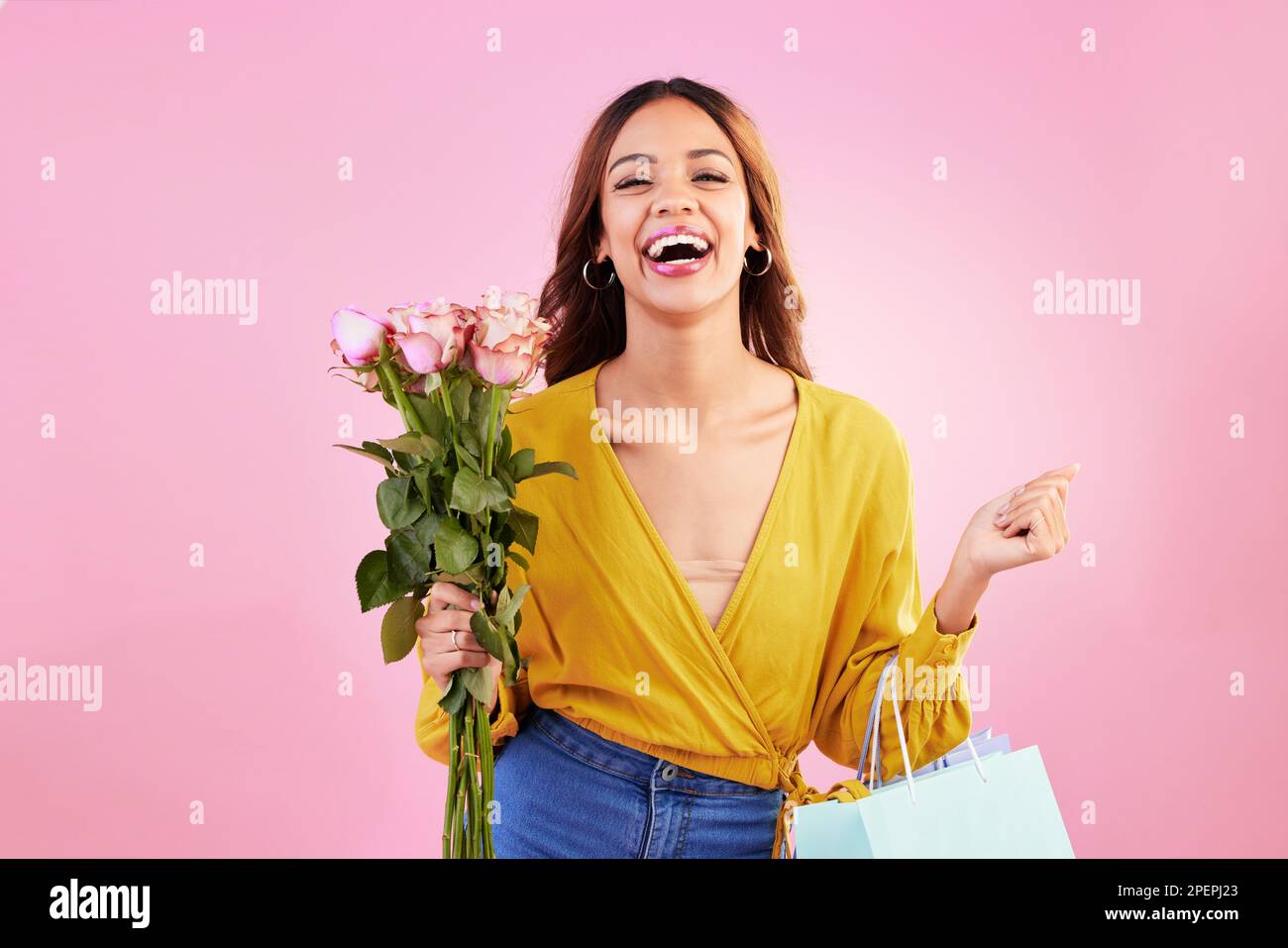 Happy, shopping bags and flowers with woman in studio for retail ...