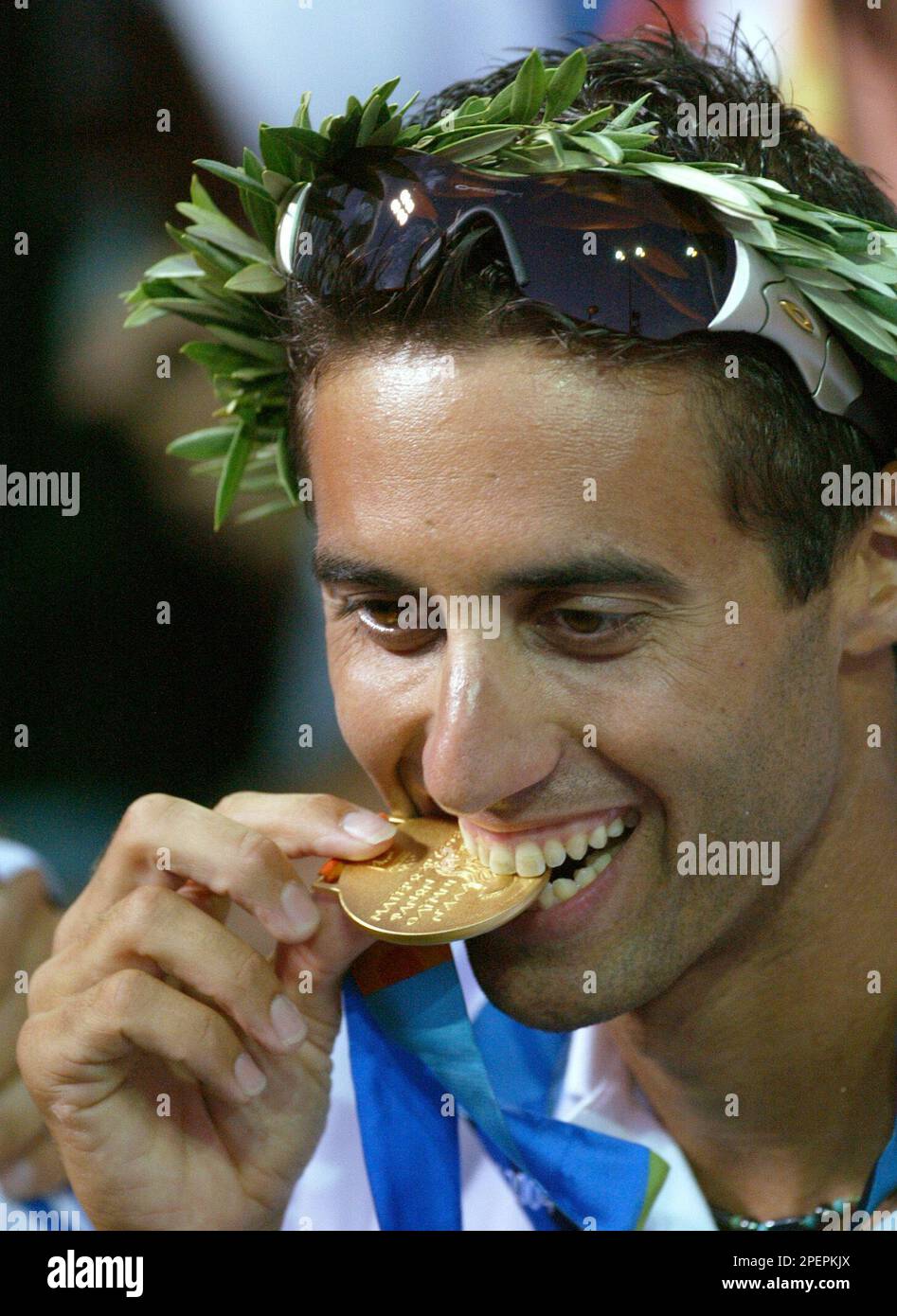 Israel's Gal Fridman bites his gold medal after the Men's Mistral ...