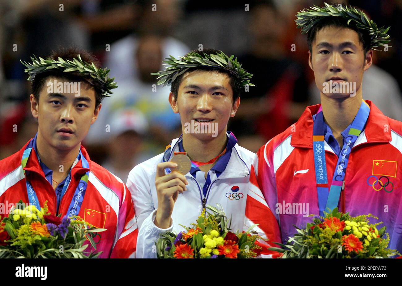 South Korea's Ryu Seung Min, center, shows his gold medal after defeated China's Wang Hao, left ...