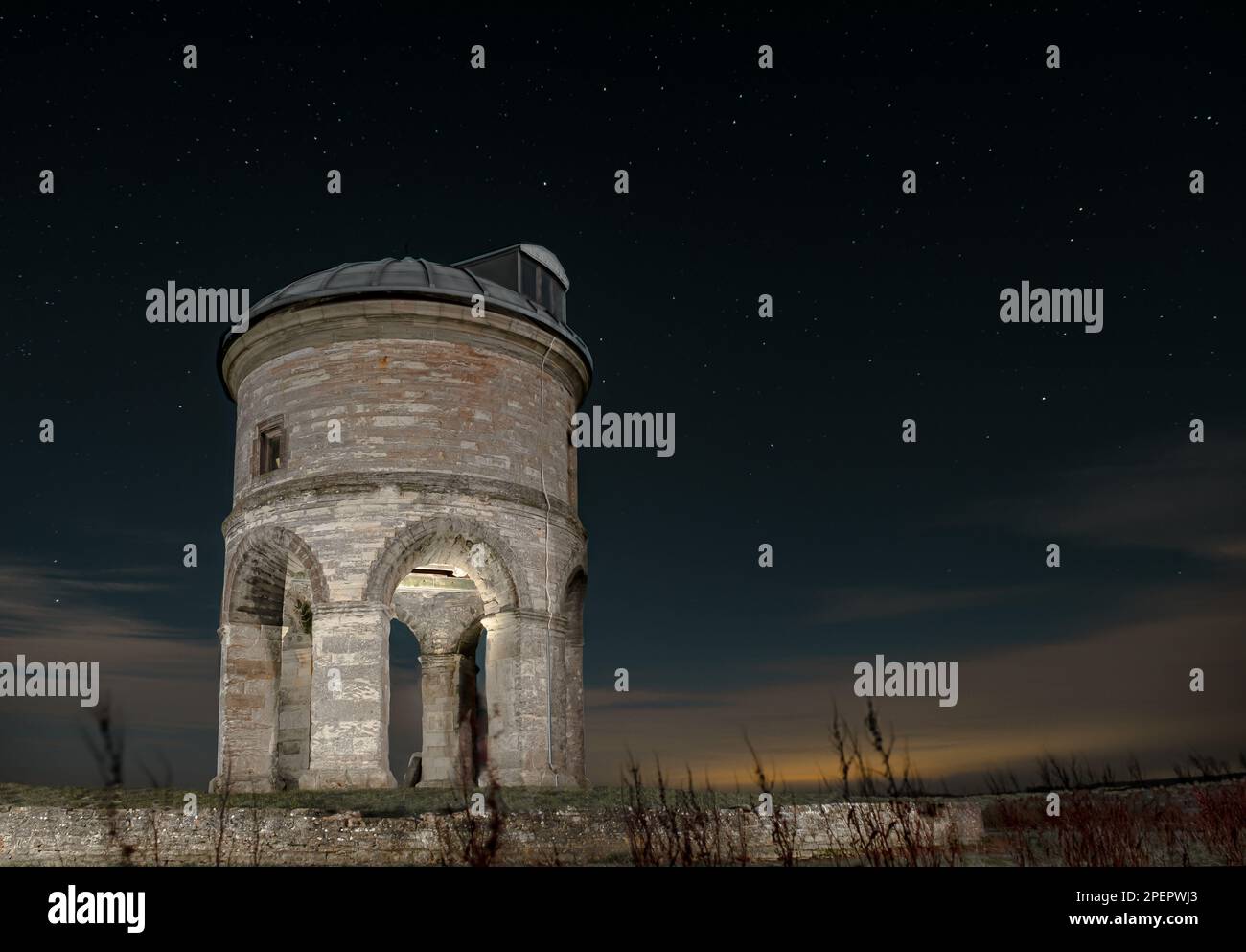 Stone Windmill Tower at Night with starry sky and light painting Stock ...