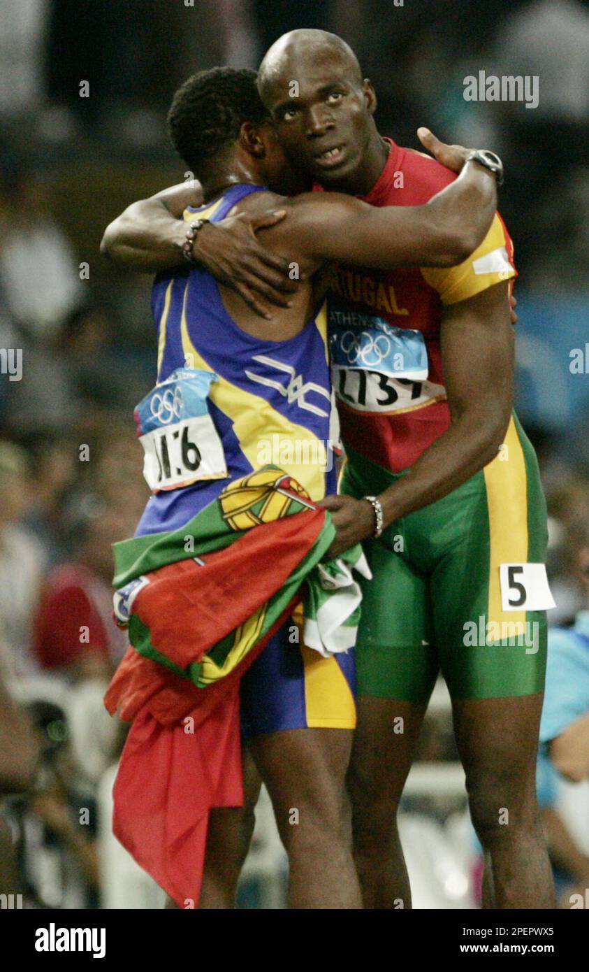 Portugal's Francis Obikwelu holds the Portuguese flag, as he embraces ...