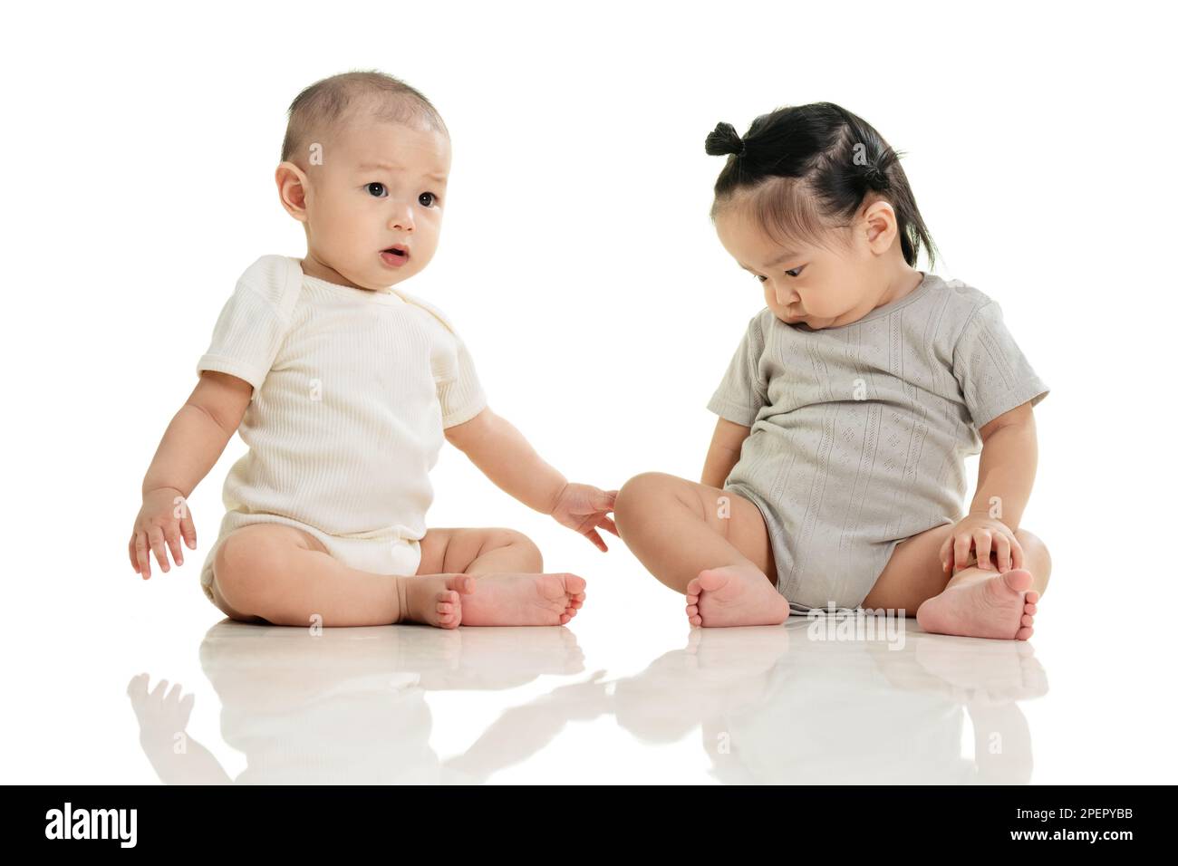 Playing two cute baby sitting on the ground Stock Photo - Alamy