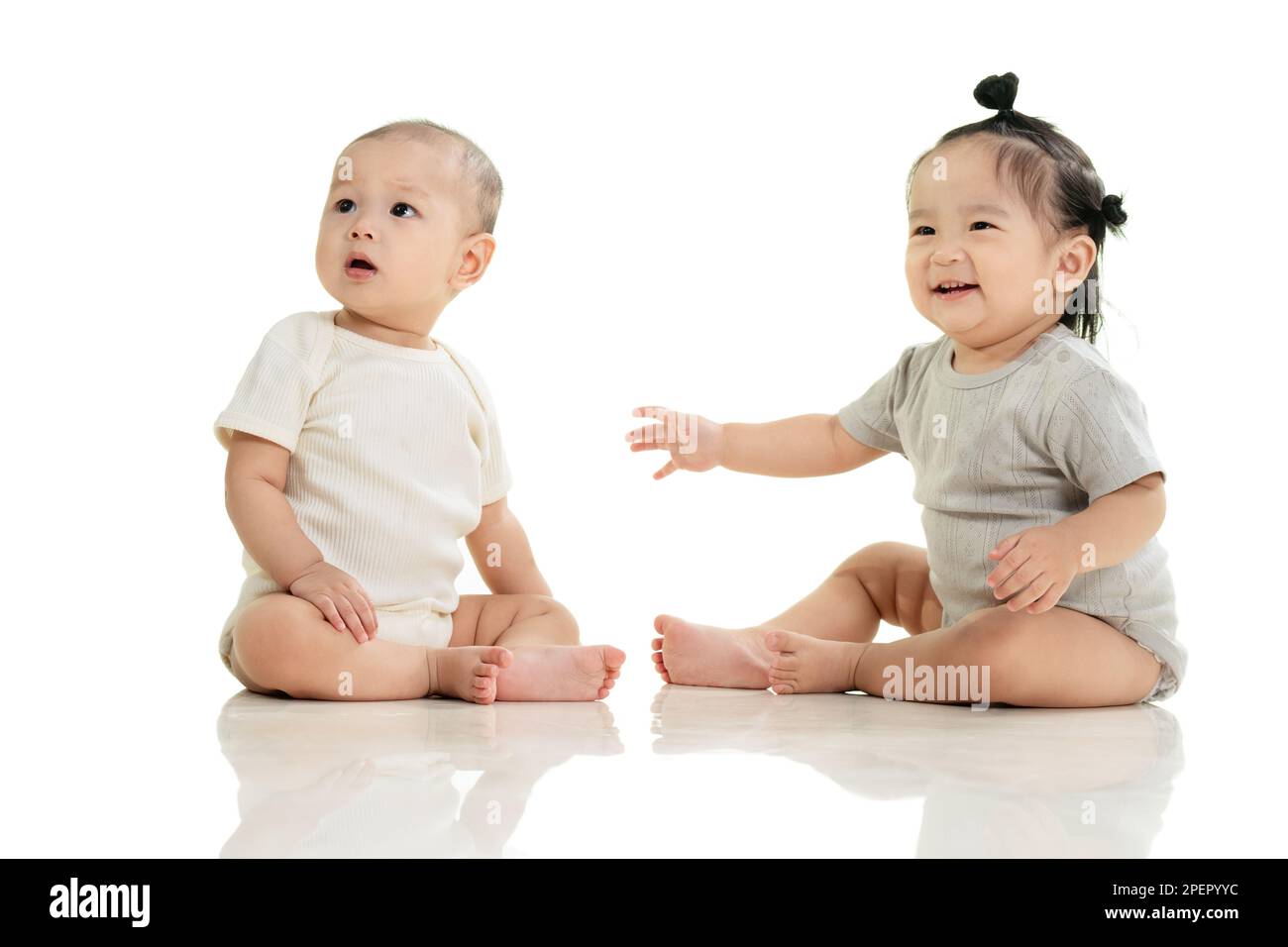 Playing two cute baby sitting on the ground Stock Photo - Alamy
