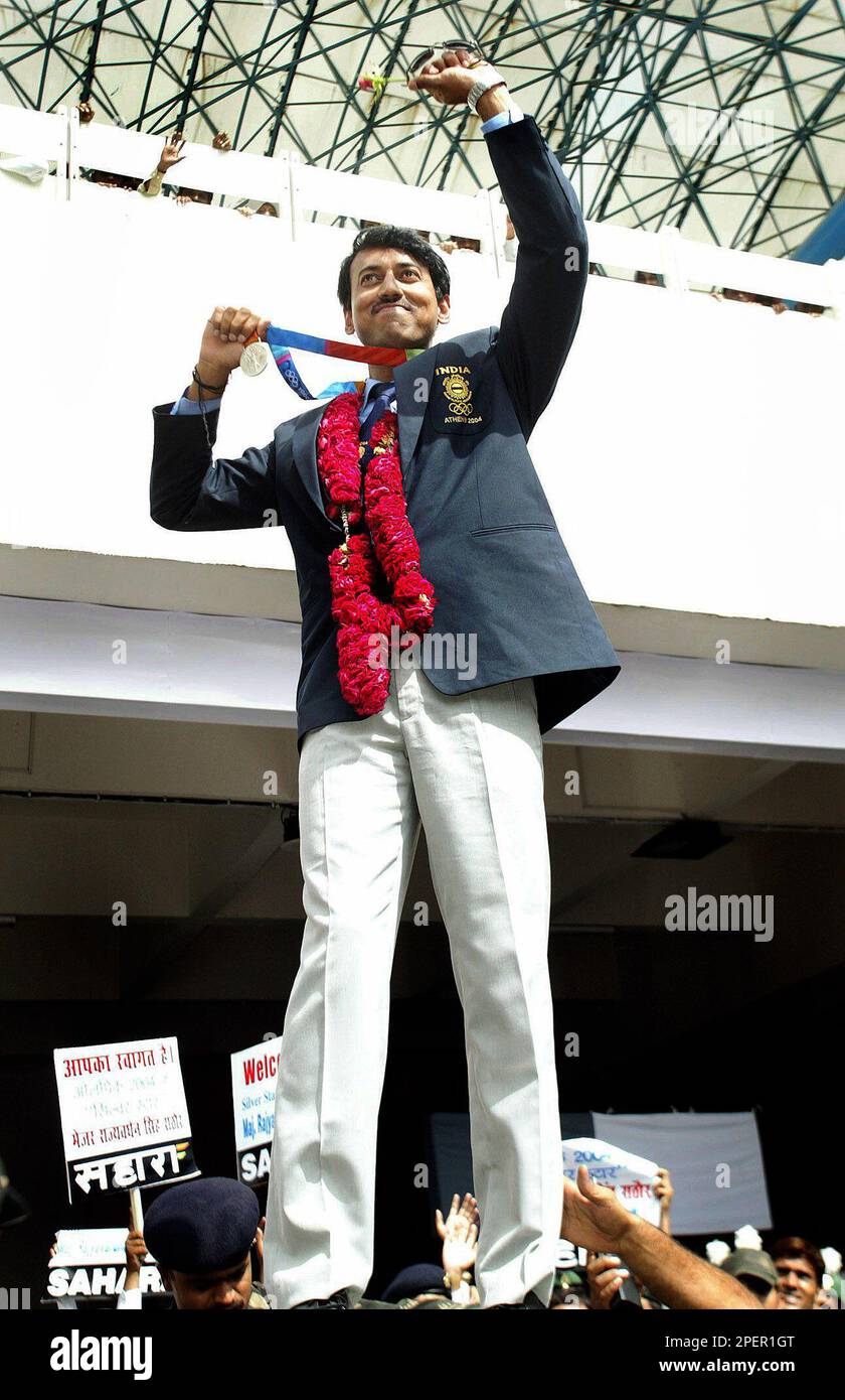Major Rajyavardhan Singh Rathore, atop a vehicle, shows his medal while ...