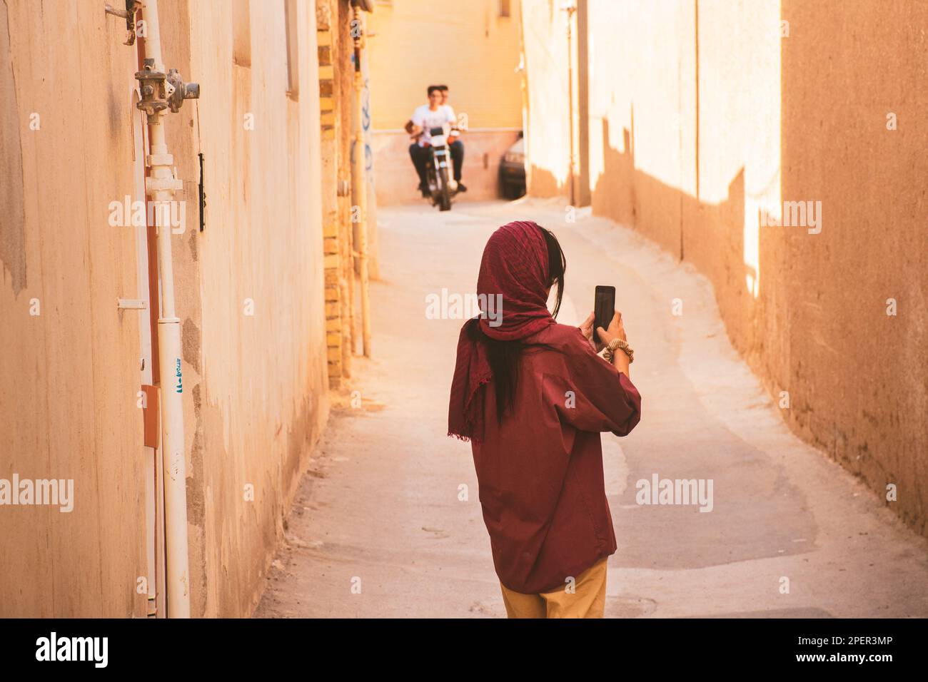 Caucasian woman tourist explore walk through arch corridor in Yazd old ...