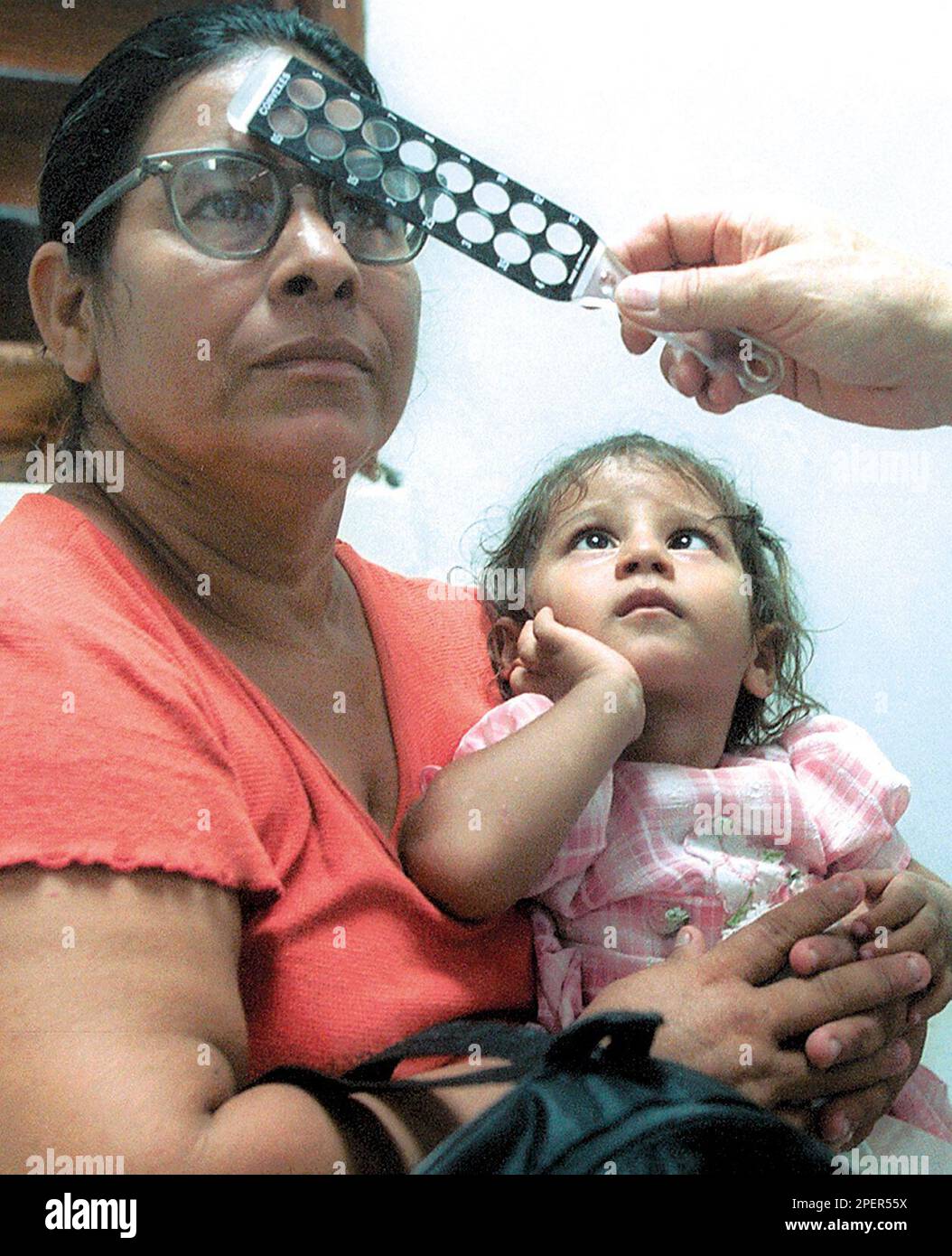 Licha Lopez, 49, has her eyeglasses checked by eye doctor Terry Tack as ...