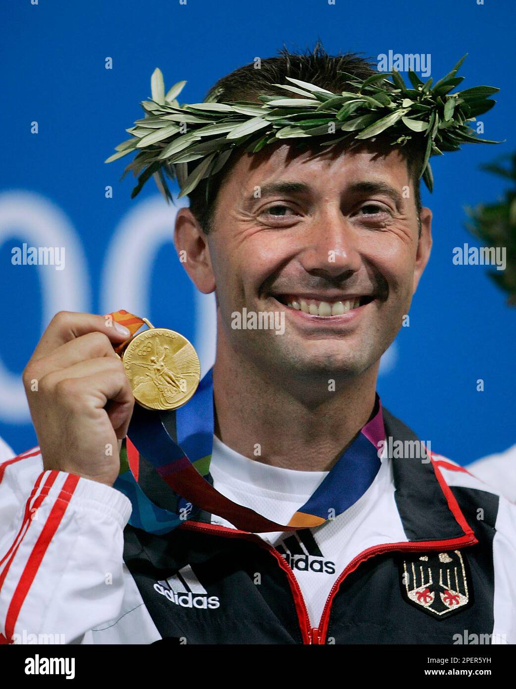 Germany's Manfred Kurzer shows off his gold medal on the podium after ...
