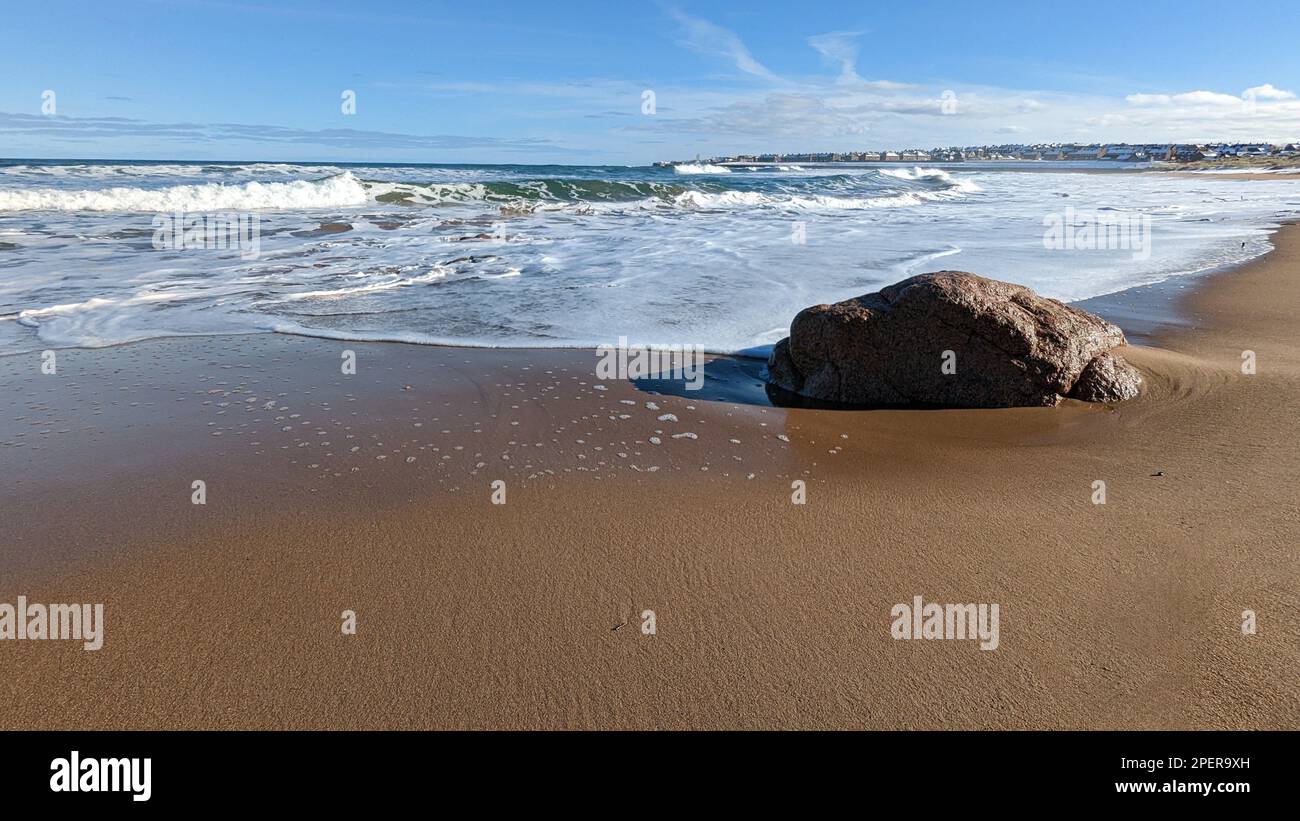 Rock being engulfed by tide Stock Photo - Alamy