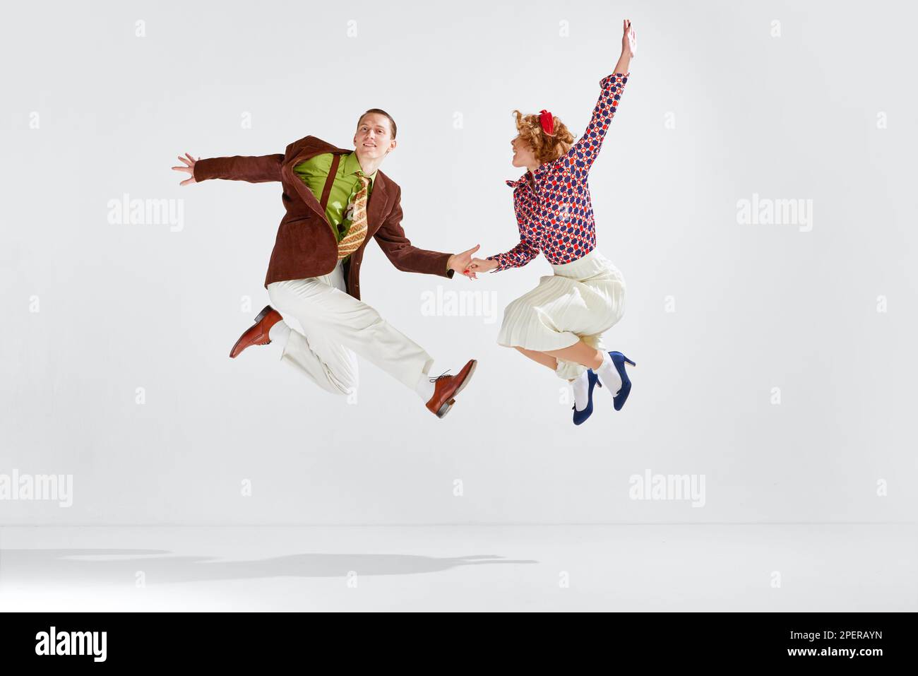 Jumping high and having fun. Young man and woman in stylish clothes ...
