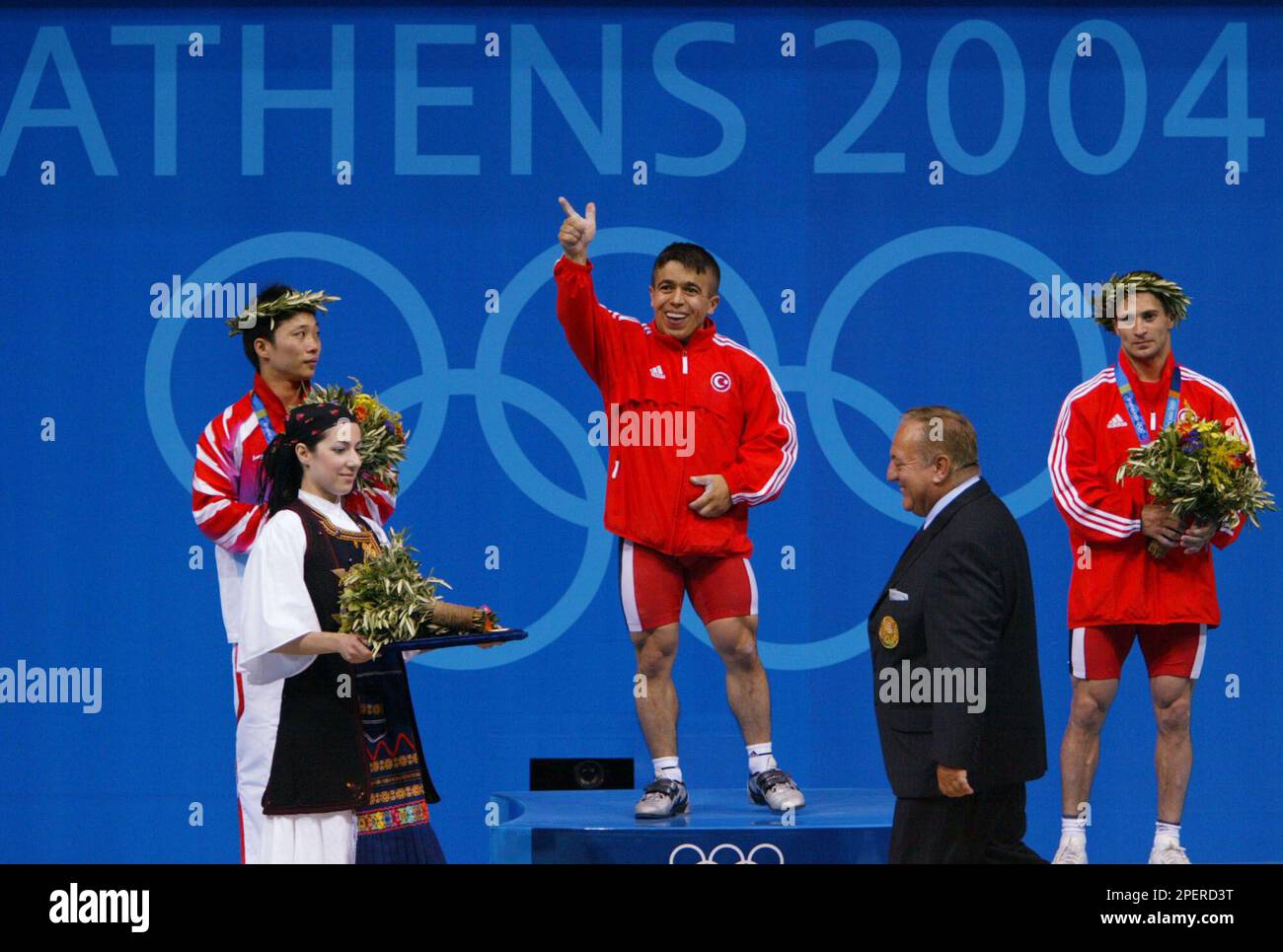 Turkish 56 kg weightlifter Halil Mutlu, center, signals to a crowd of ...
