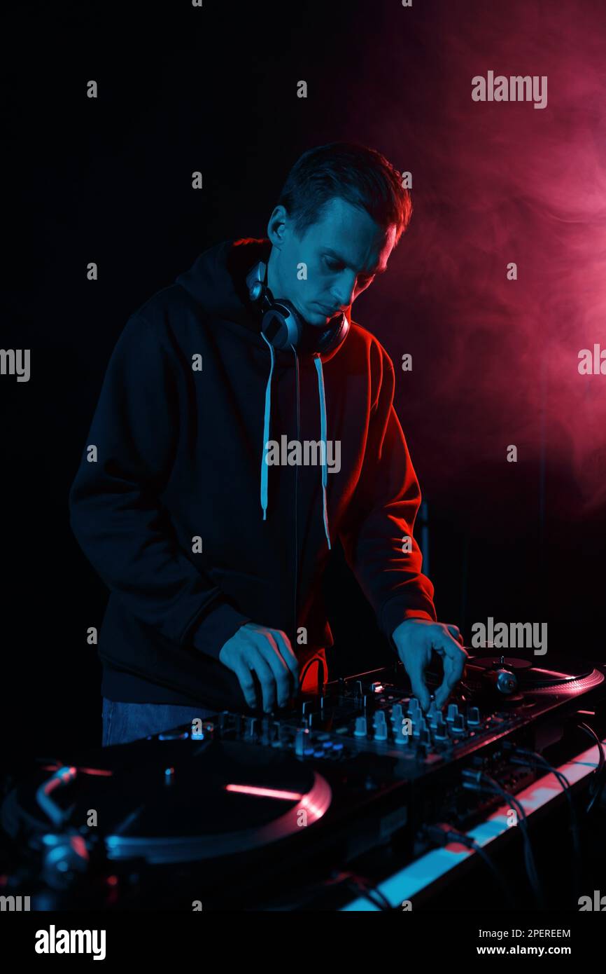 Cool young DJ playing vinyls on party. Disk jokey mixing musical tracks ...