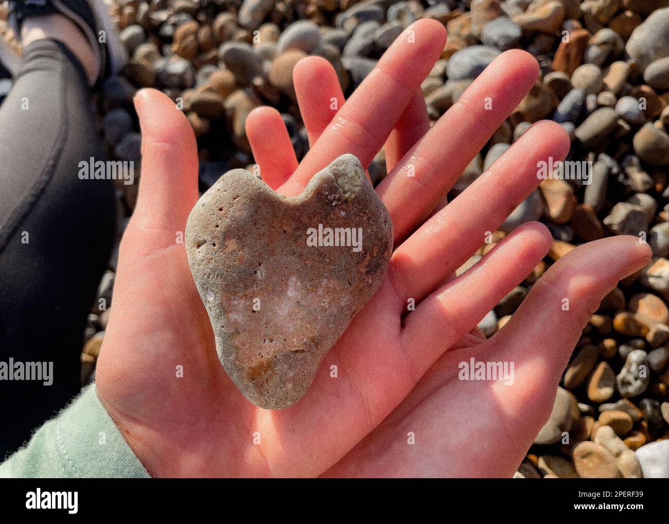 Heart shaped pebble in hands - Brighton Beach - Brighton & Hove, East ...