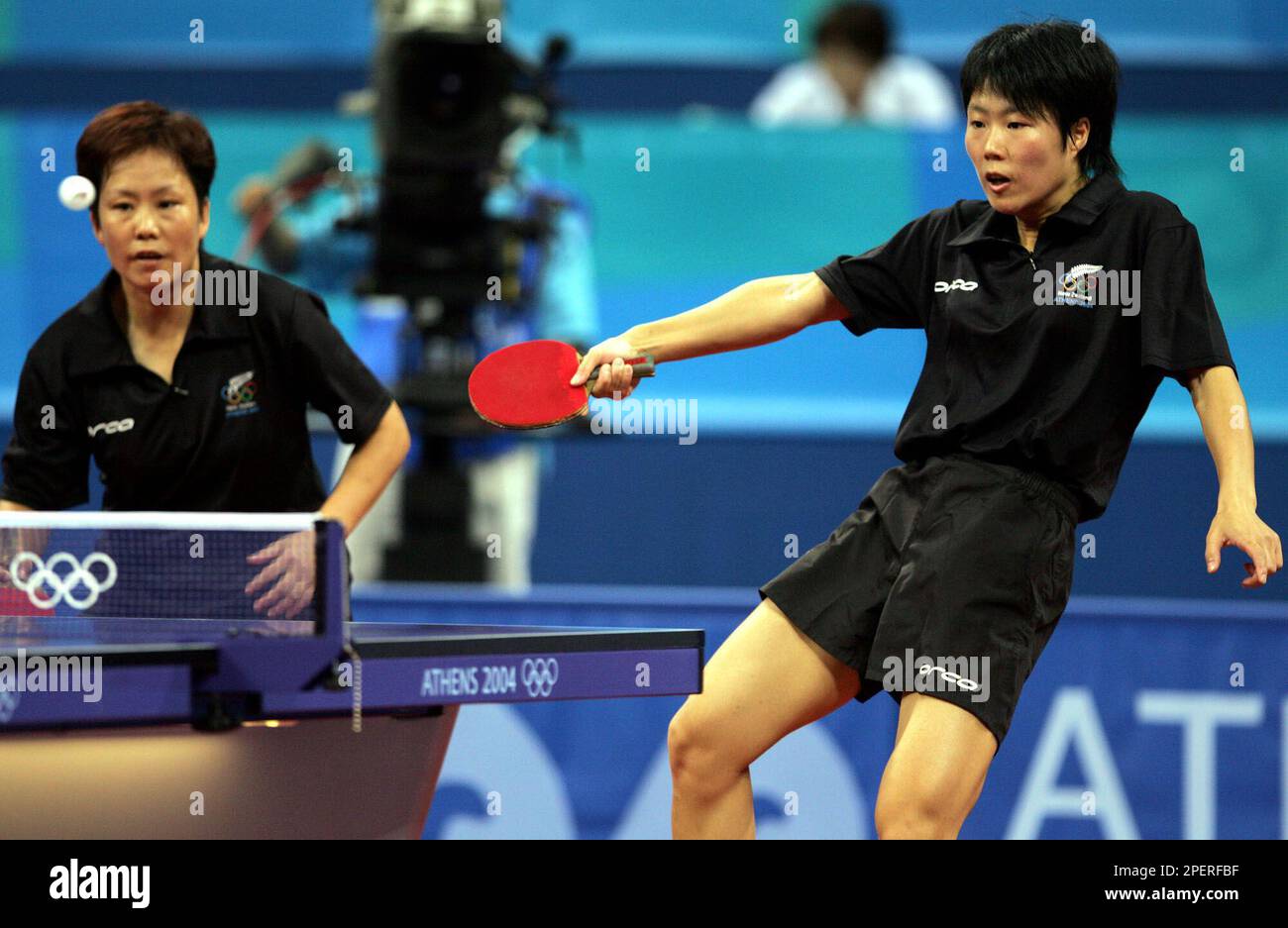 New Zealand's Karen Li, right, returns a serve as her teamate Chunli Li watching, against ...