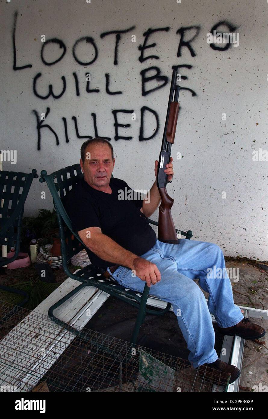 Terry Frey, of Port Charlotte, Fla., guards his house with a shotgun ...