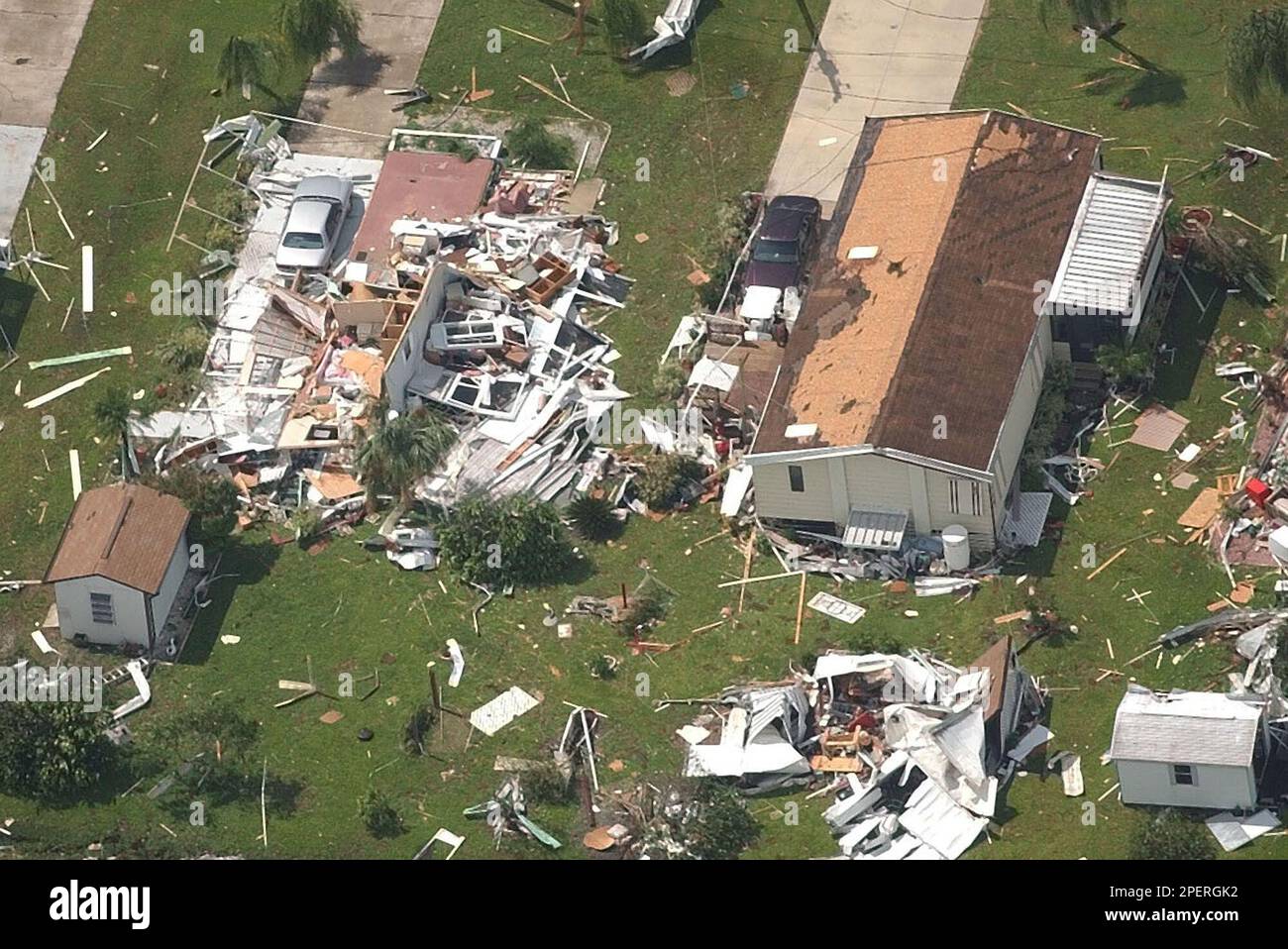 A home destroyed by Hurricane Charley, left, lies in ruin next to its ...