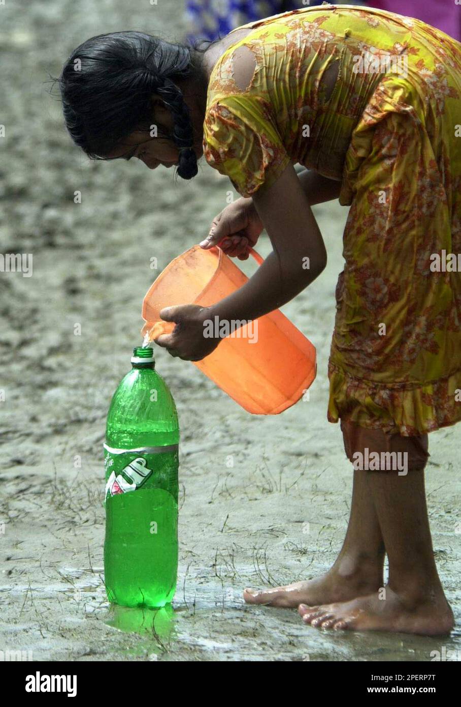 A girl fills a bottle with drinking water at a flood relief camp at ...