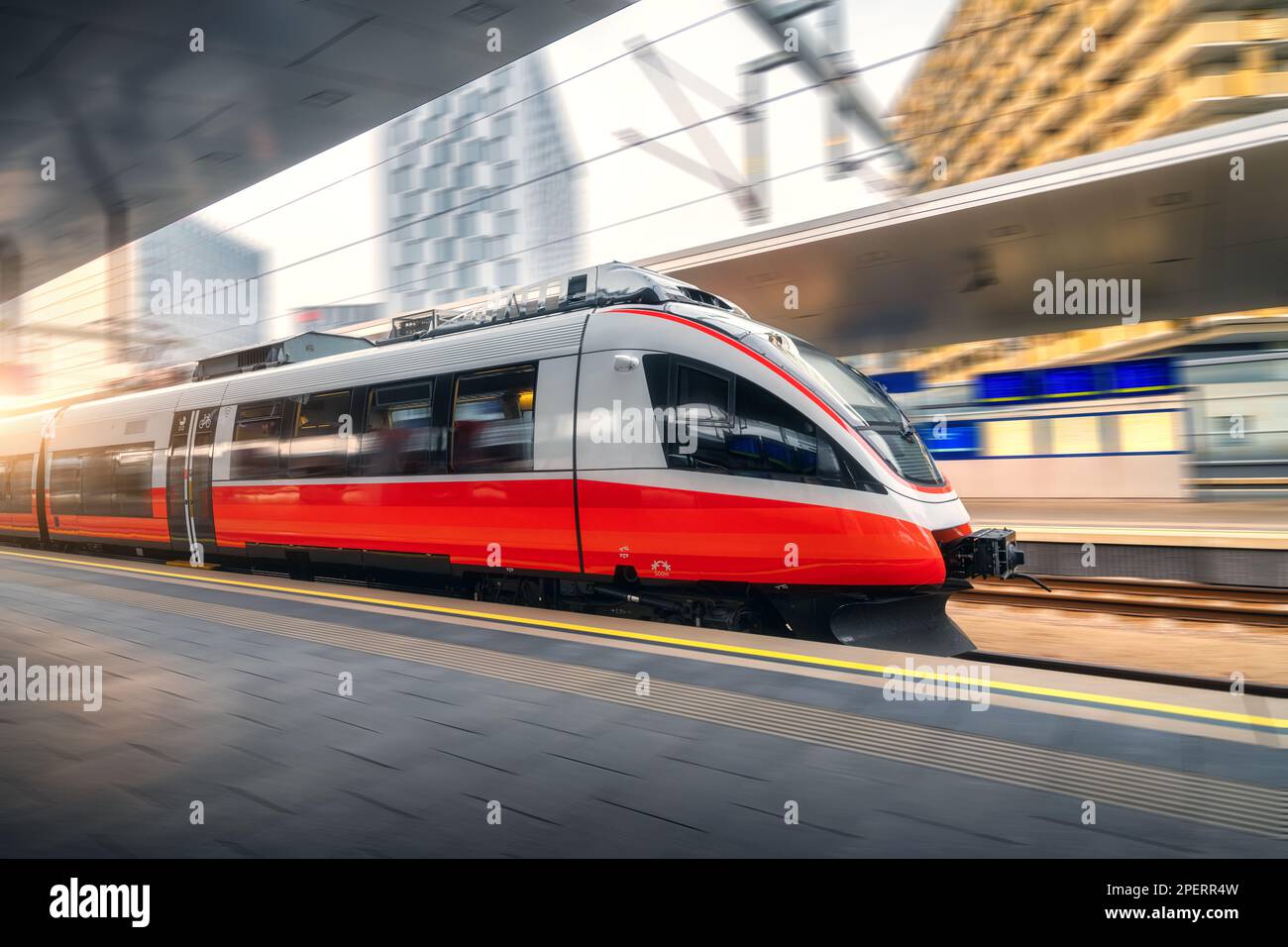Red high speed train in motion on the railway station at sunset Stock ...