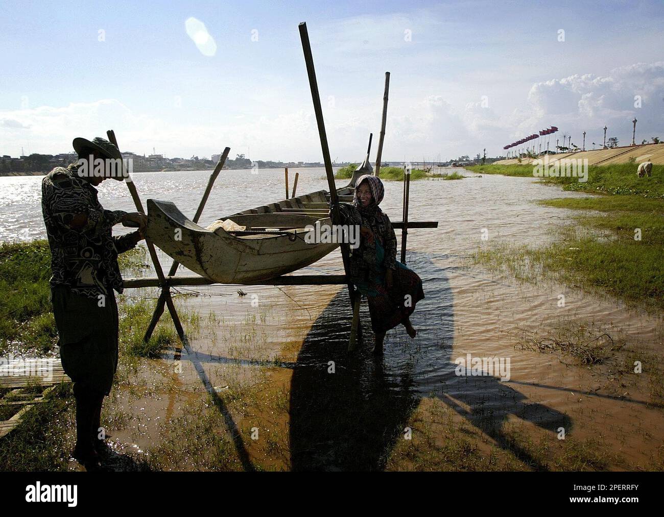 Cambodian fisherman repairs his traditional wooden fishing boat on the ...